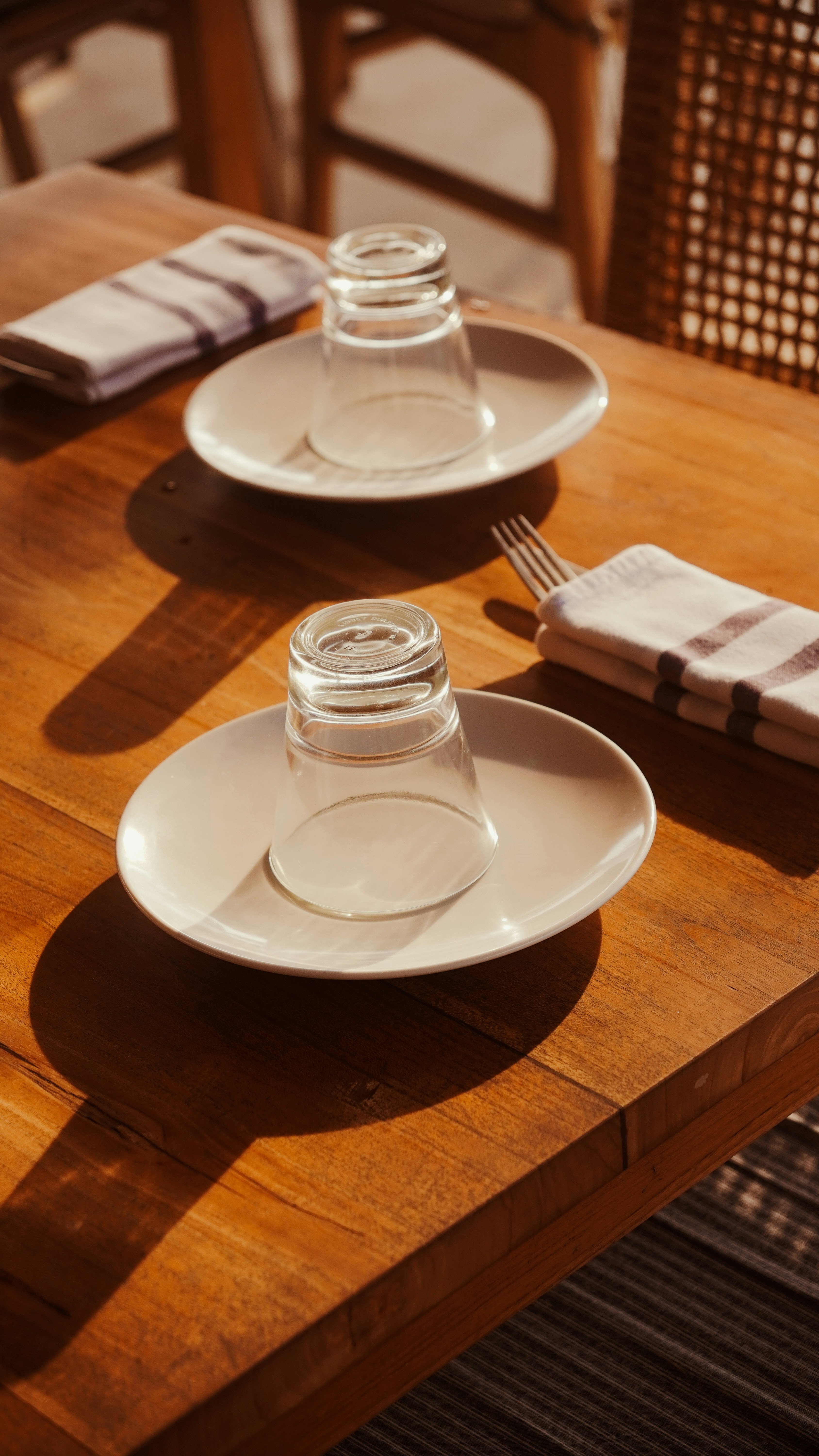 Glass on Wood: Sunlit Place Setting at a Cozy Table