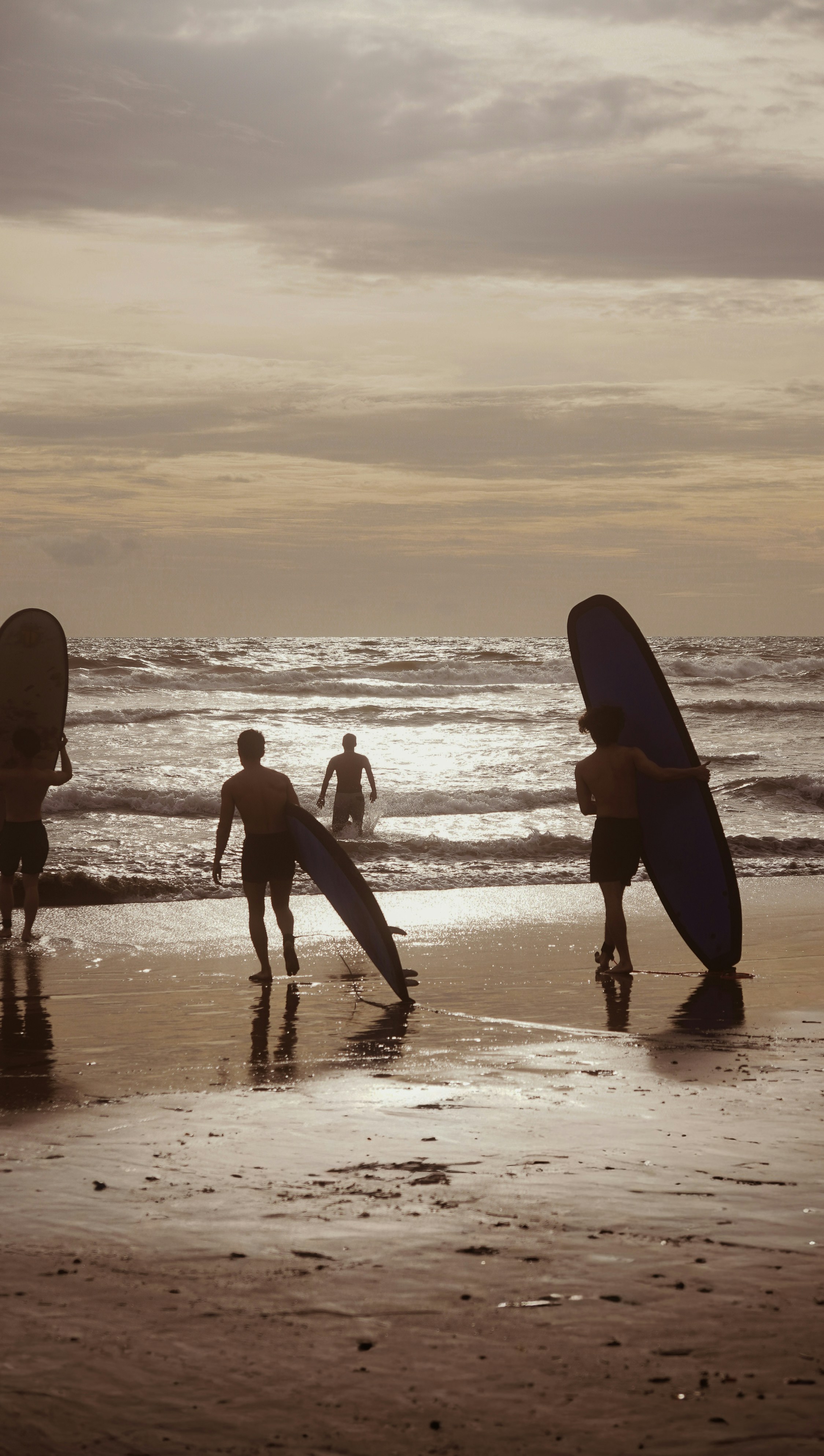 Sundown Surf: Silhouetted Surfers Return to Quiet Shore