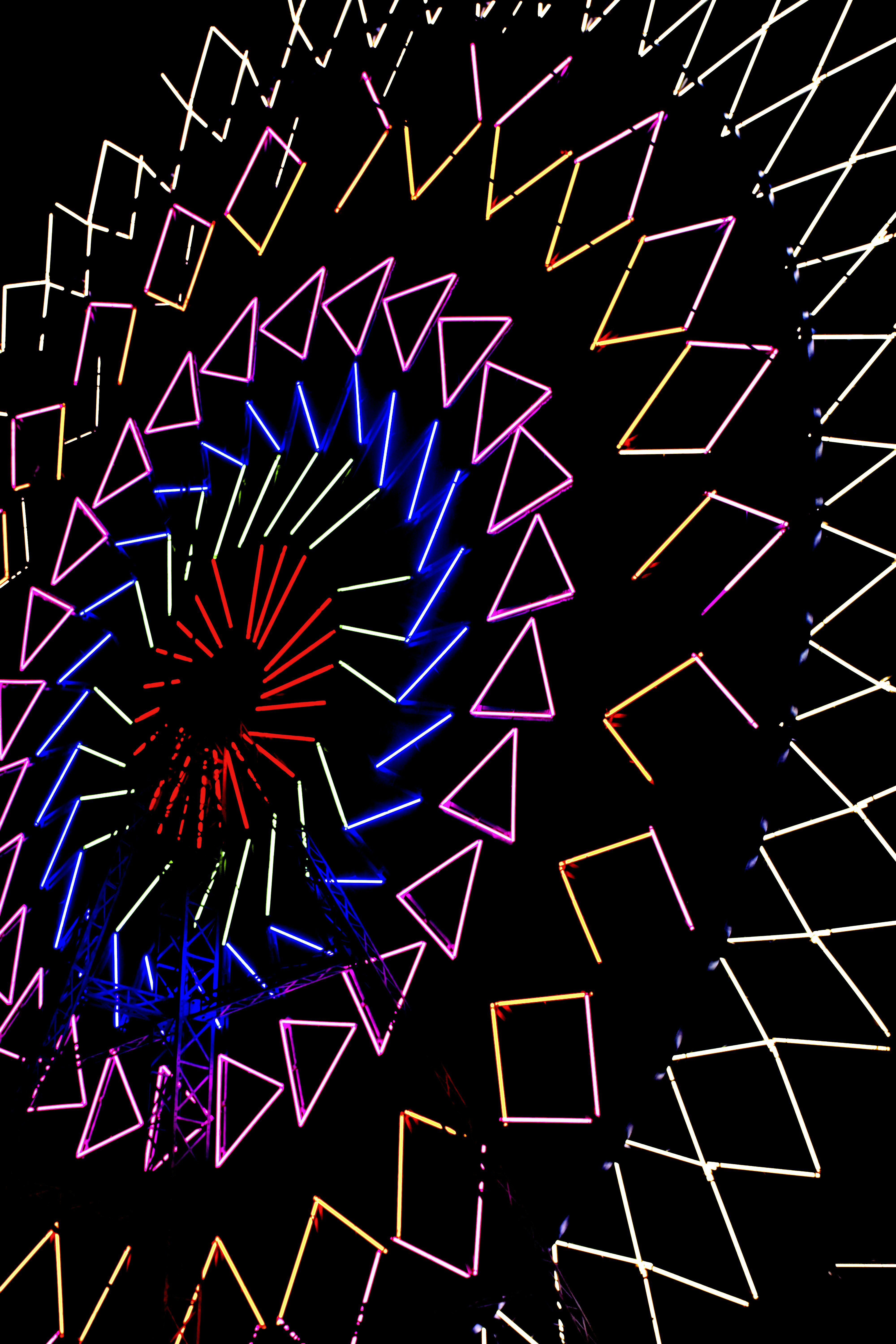 Neon Spiral: A Nighttime Ferris Wheel in Prismed Arcs