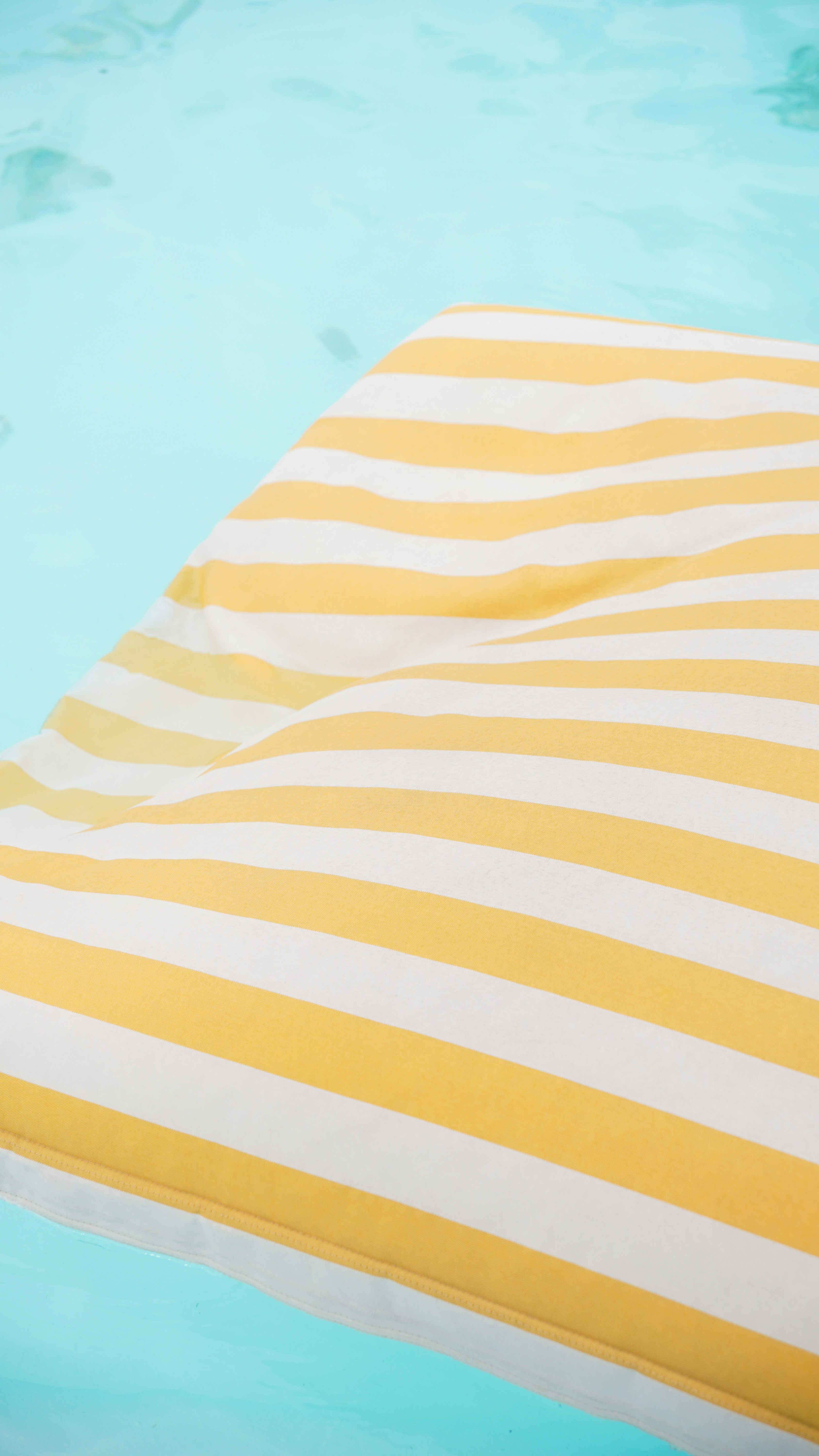Stripe of Sunshine: A Summer Lounger Drifts in Poolside Calm