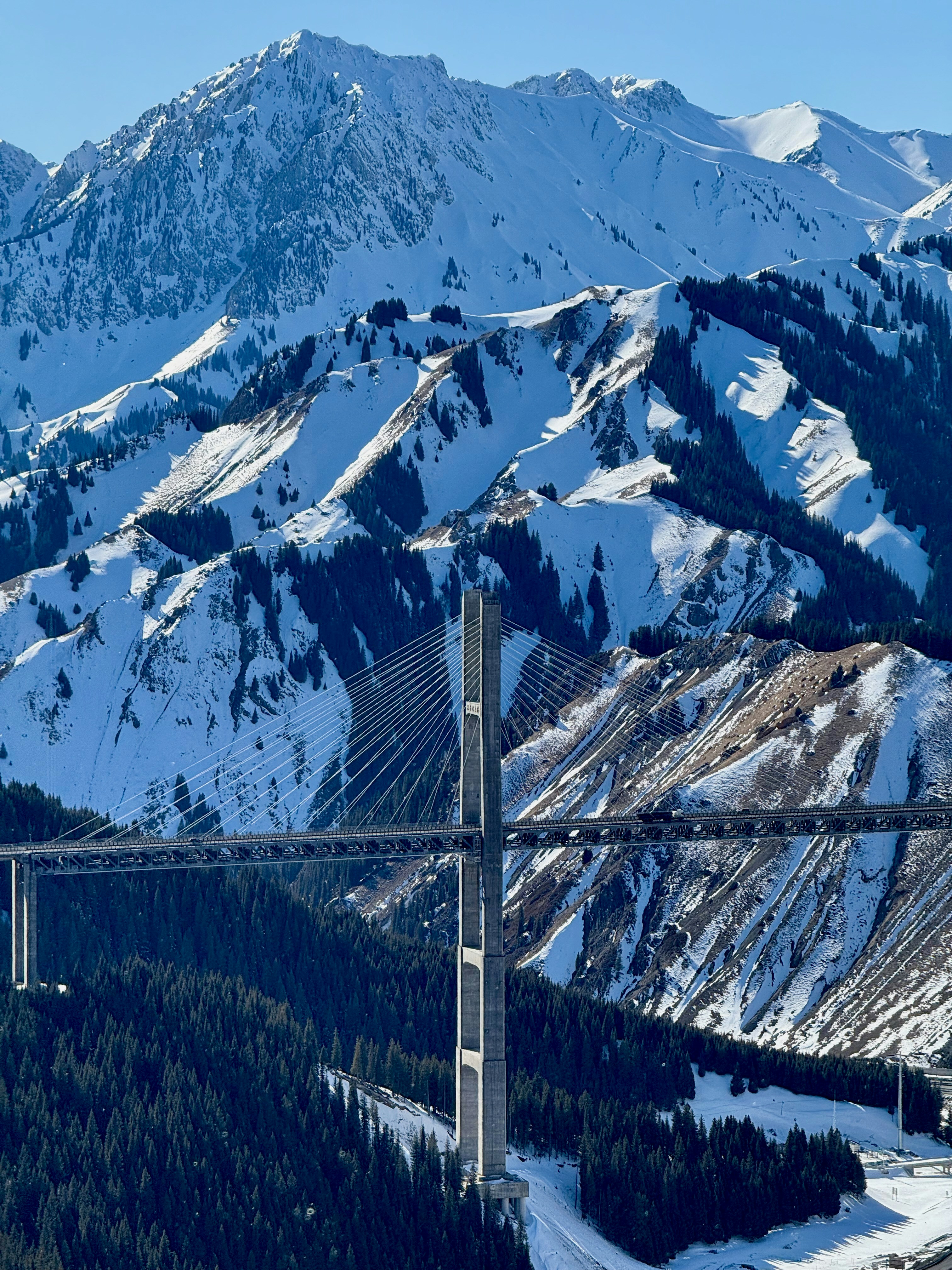 Cables and Peaks: A Snow-Draped Alpine Bridge Scene