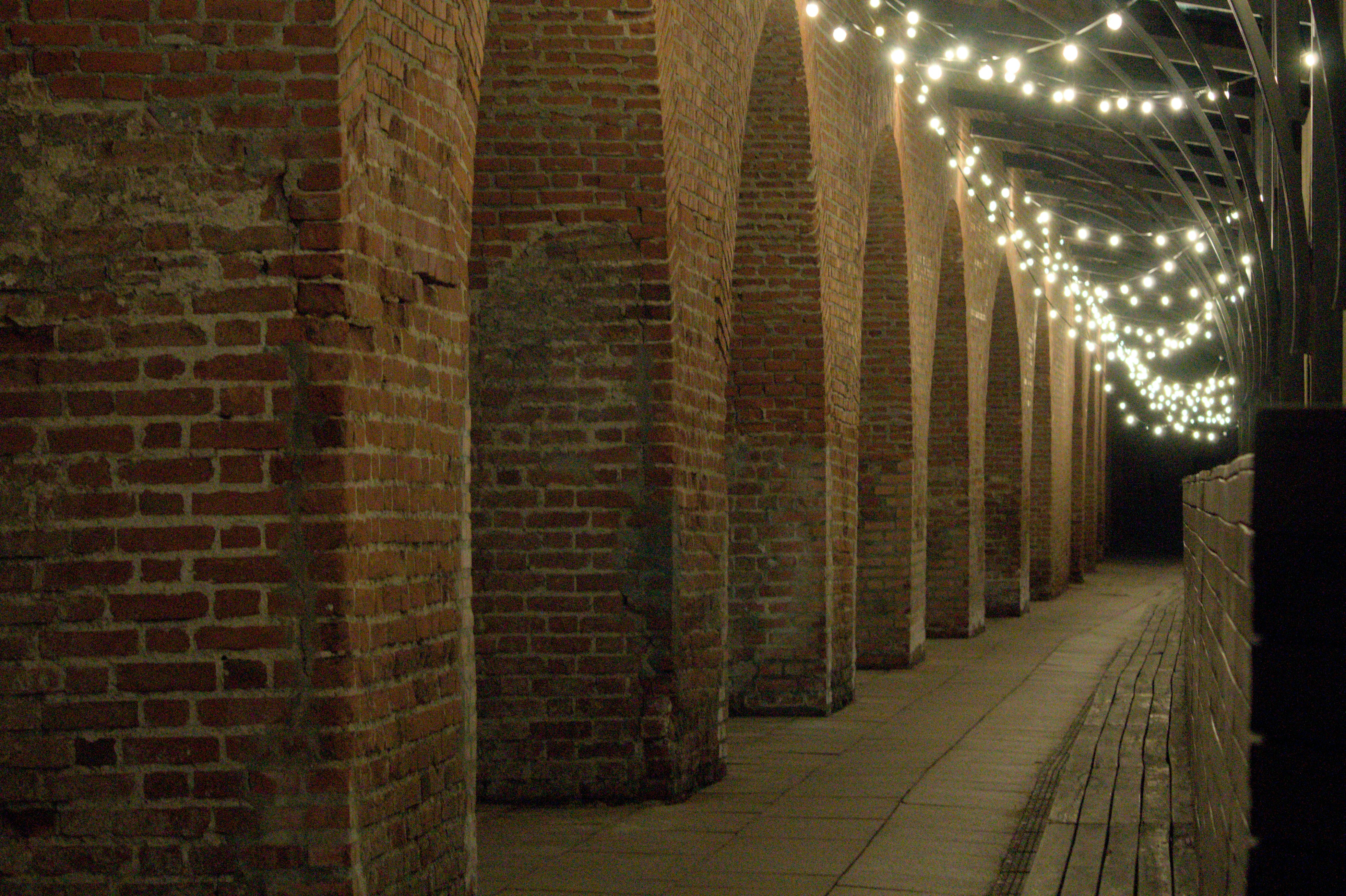 String Lights Beneath Brick Arches