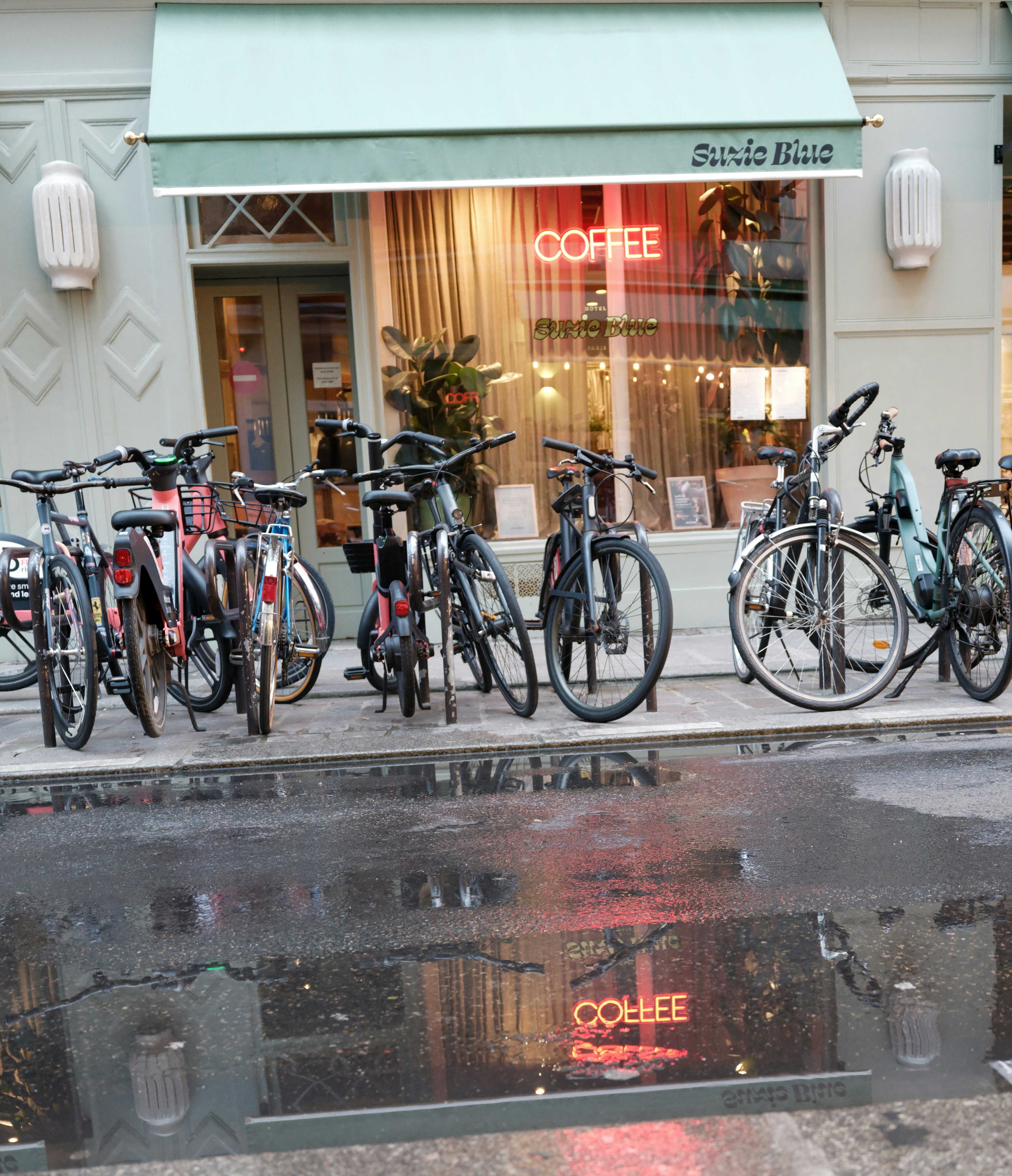 Neon Coffee Front: Bicycles Aligning the Wet Street