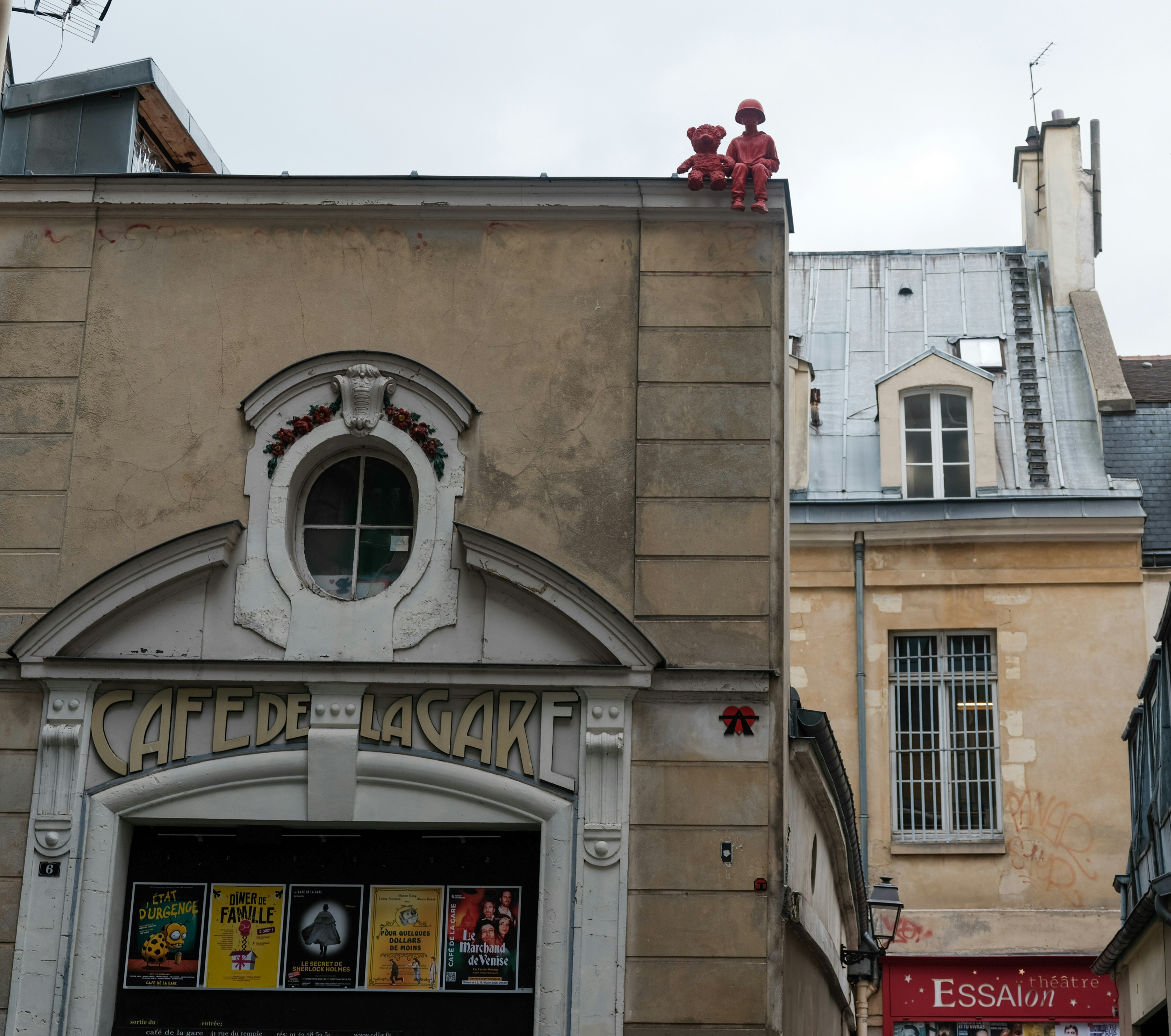 Old Café facade under a Parisian rooftop, framed by vintage architecture