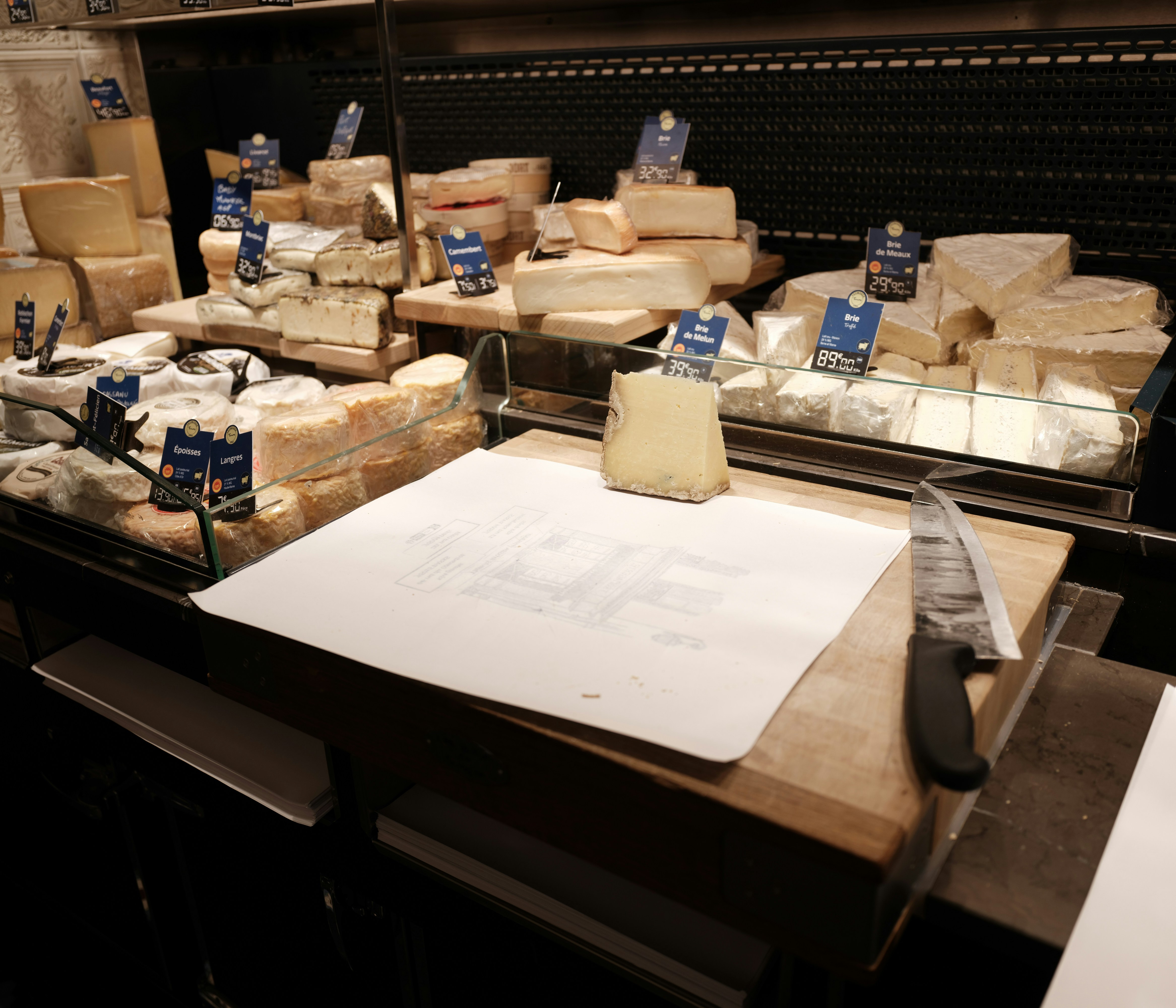 Cheese Counter Constellation: A Quiet Moment Among Wheels and Knives