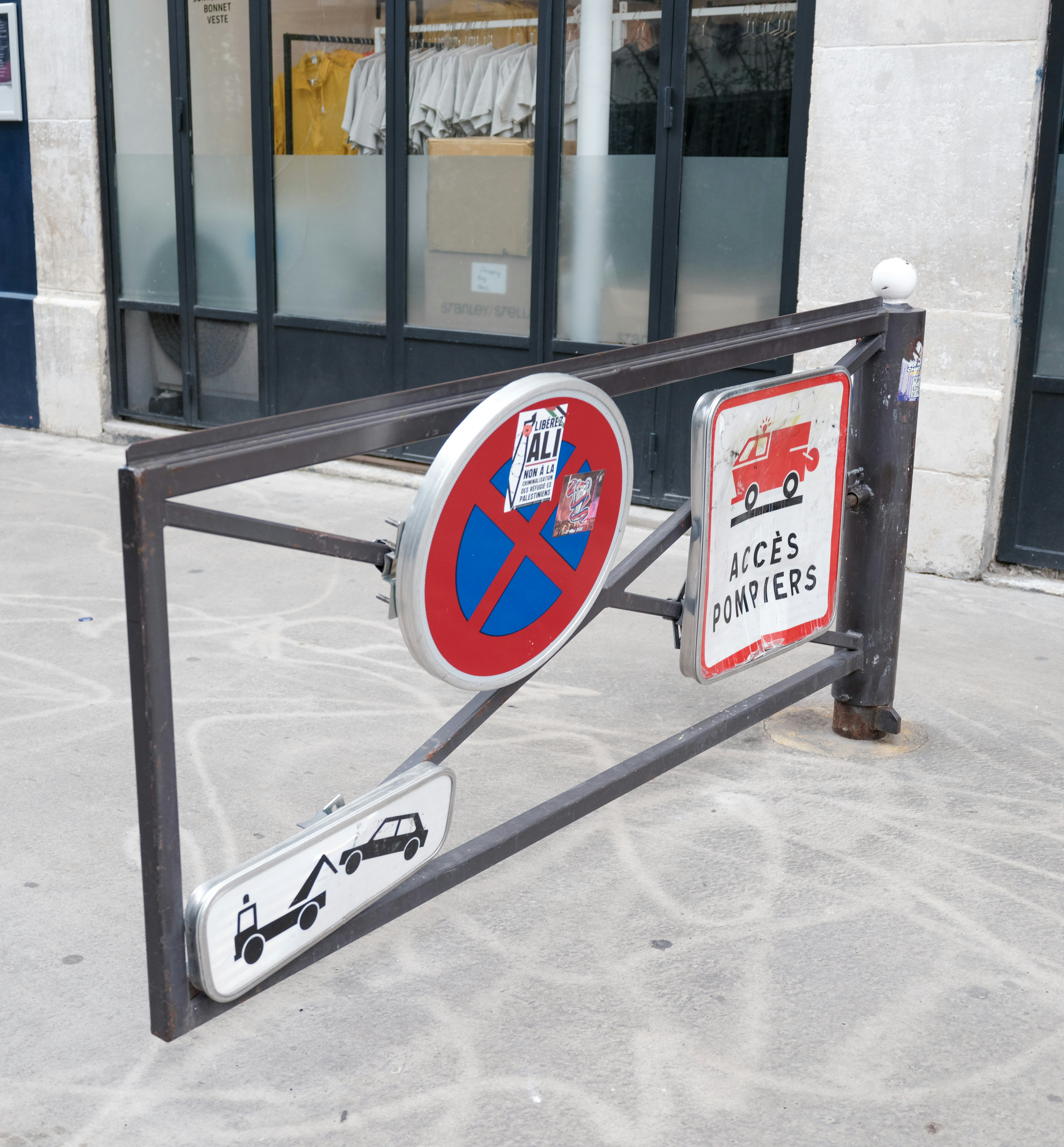 Urban No-Parking Barrier with Signage Against a Glass Frontage