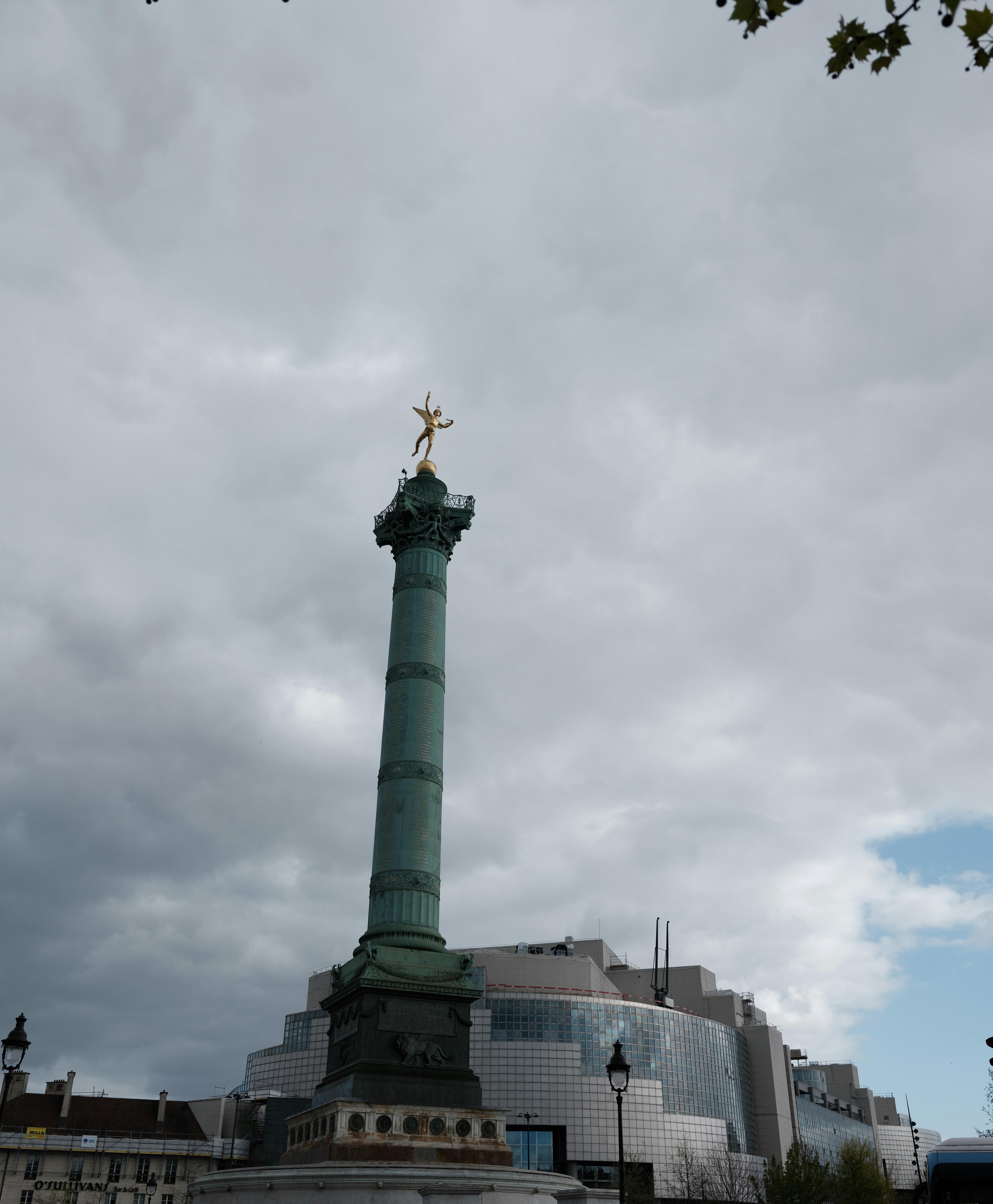 Golden Statue Reaching Above a Modern Skyline