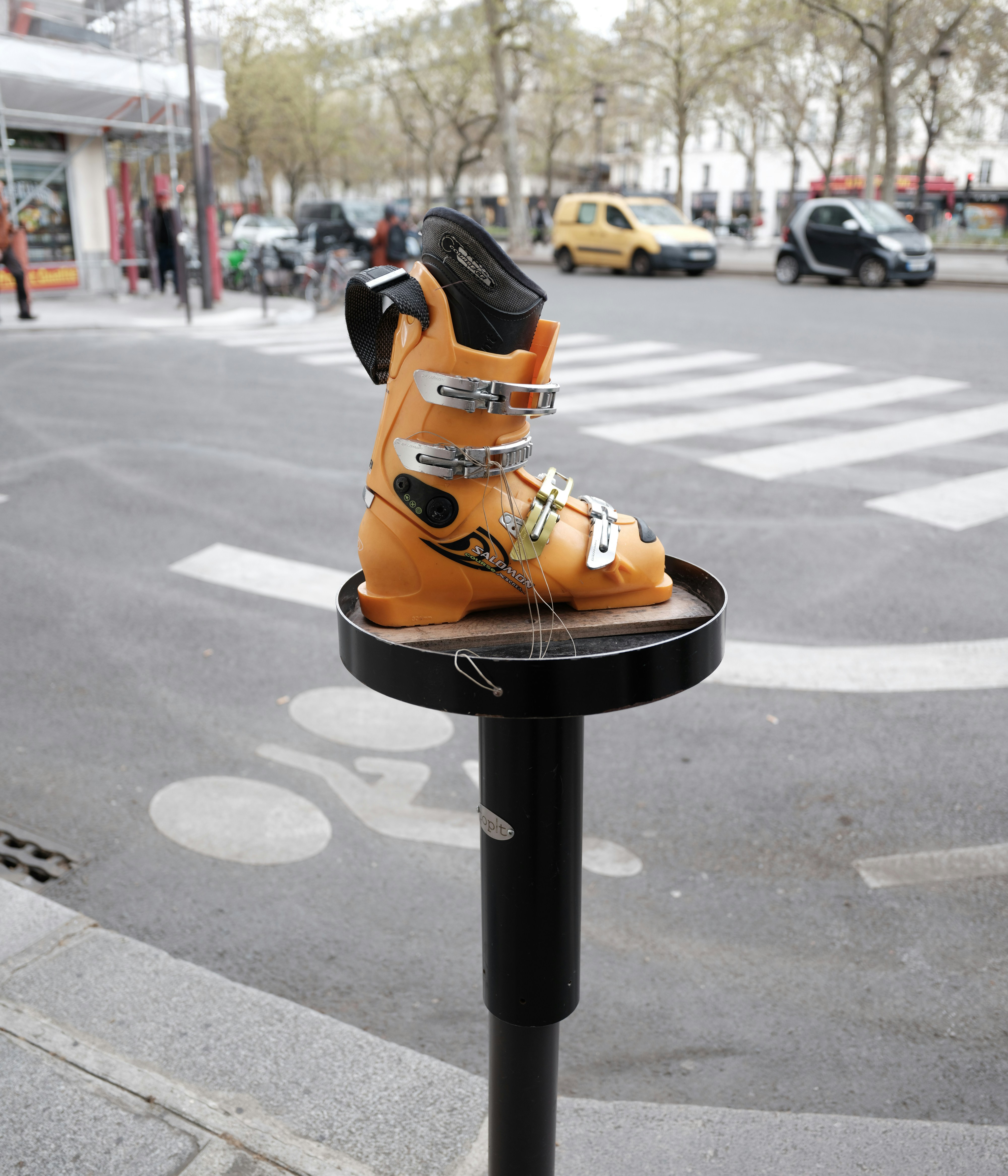 Orange ski boot on a round pedestal in a city street