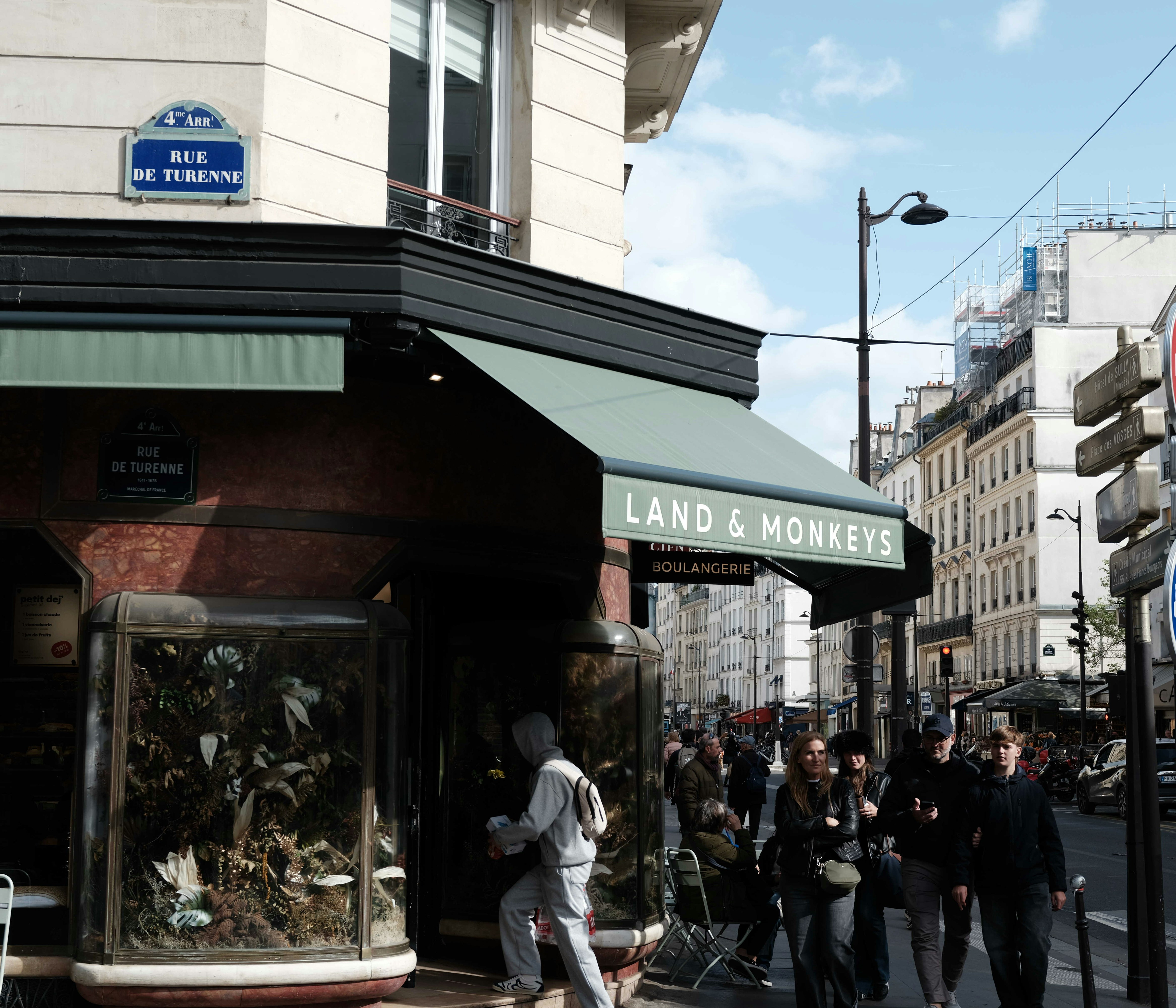 Land & Monkeys Corner: Pedestrians & Boutique Beneath a Green Awning