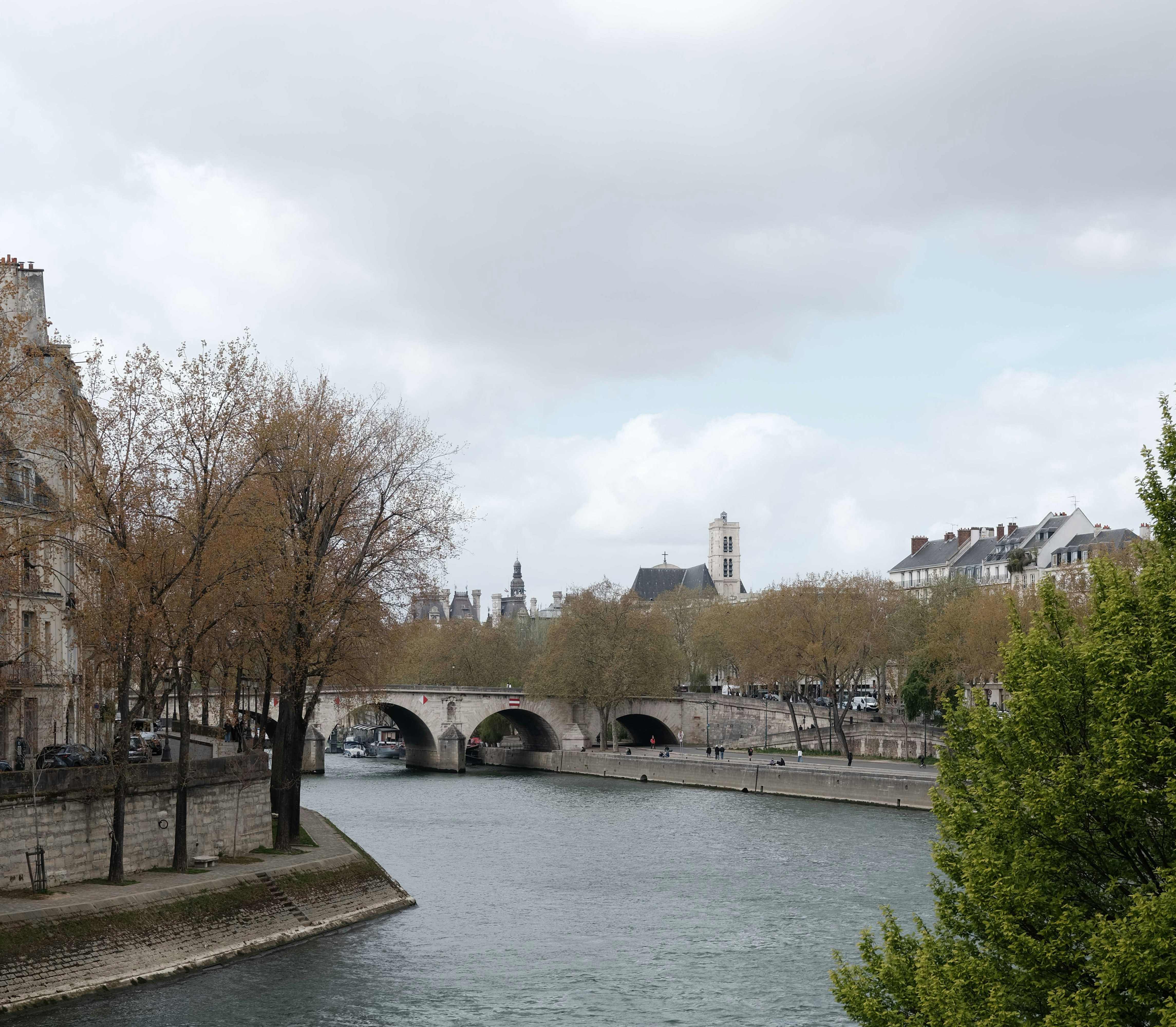 arched river with stone bridges under a cloudy sky