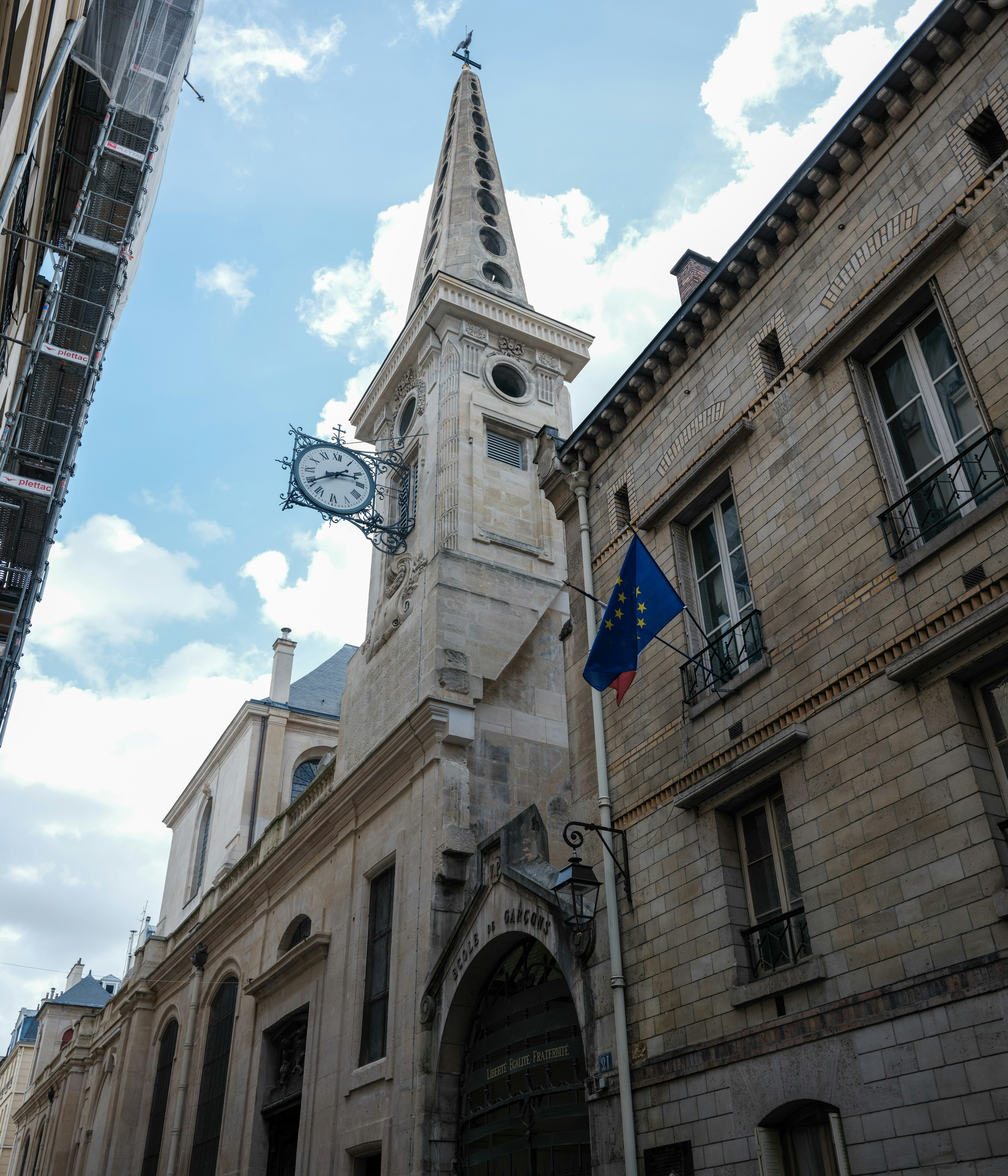 Clocktower and Flagged Facade: A Narrow Street in Sunlit Stone