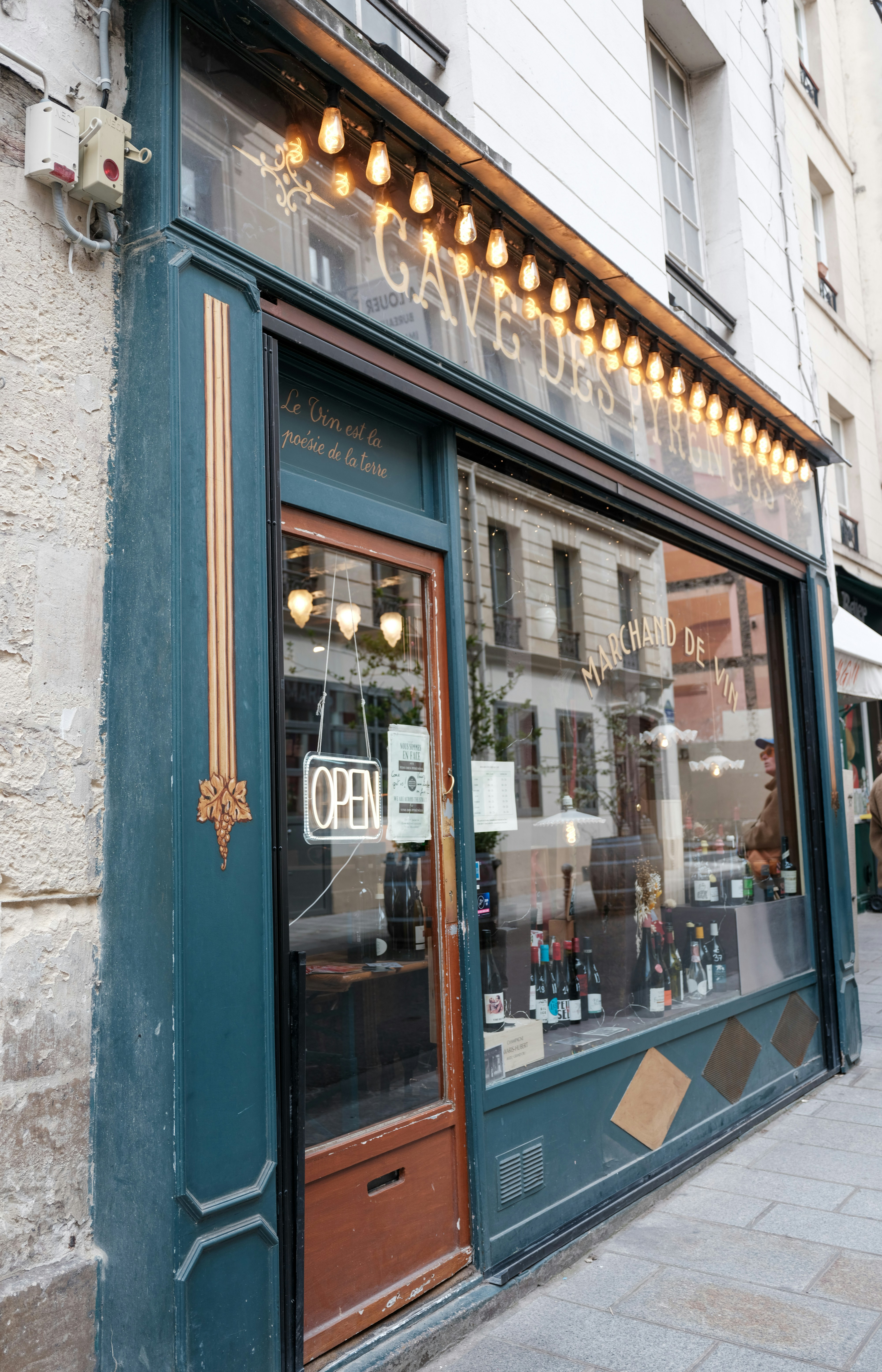 Neon-lit Parisian Café Façade Under Vintage Bulbs