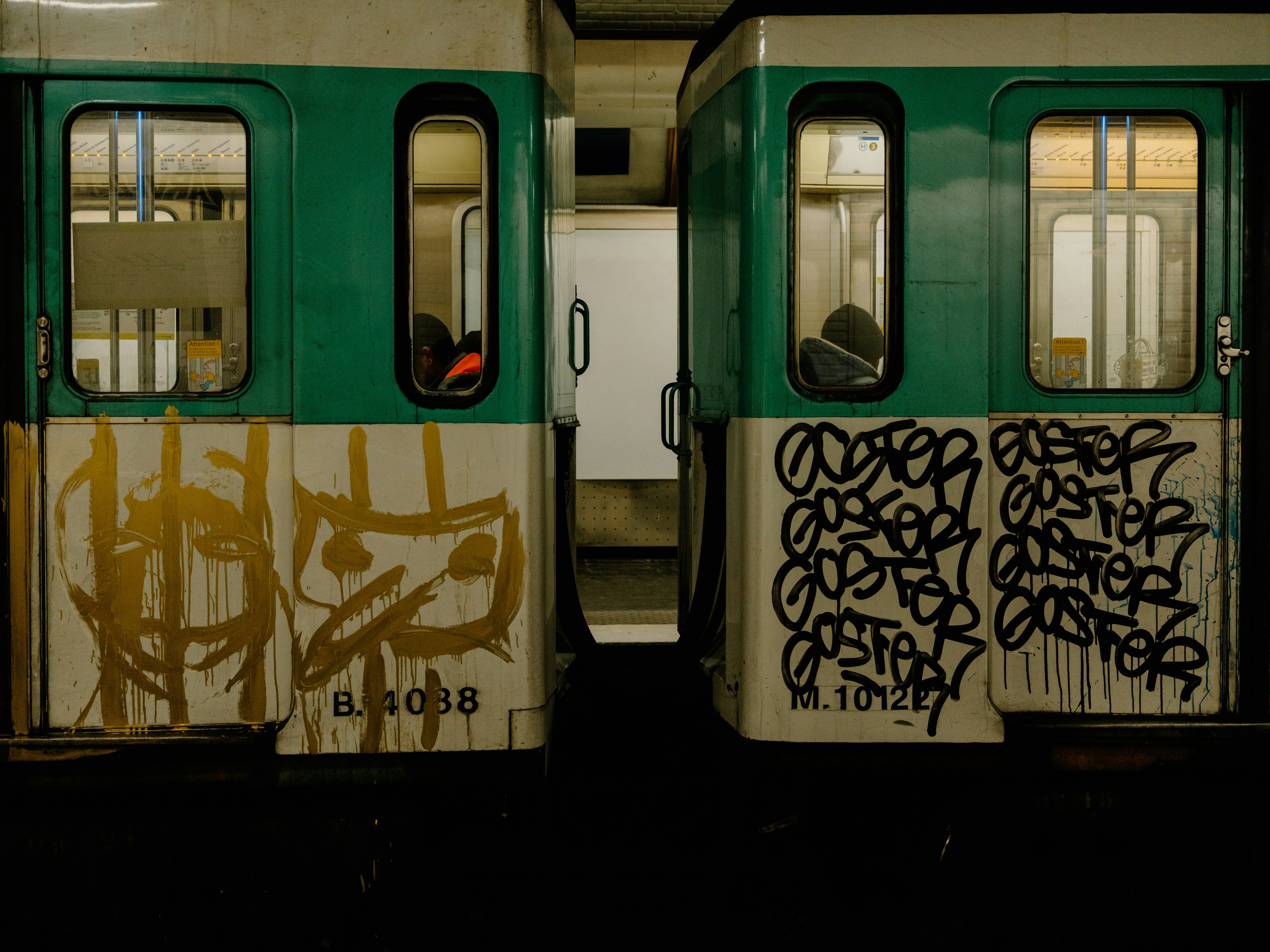Two Graffitied Subway Cars Meeting in a Narrow Night Gap