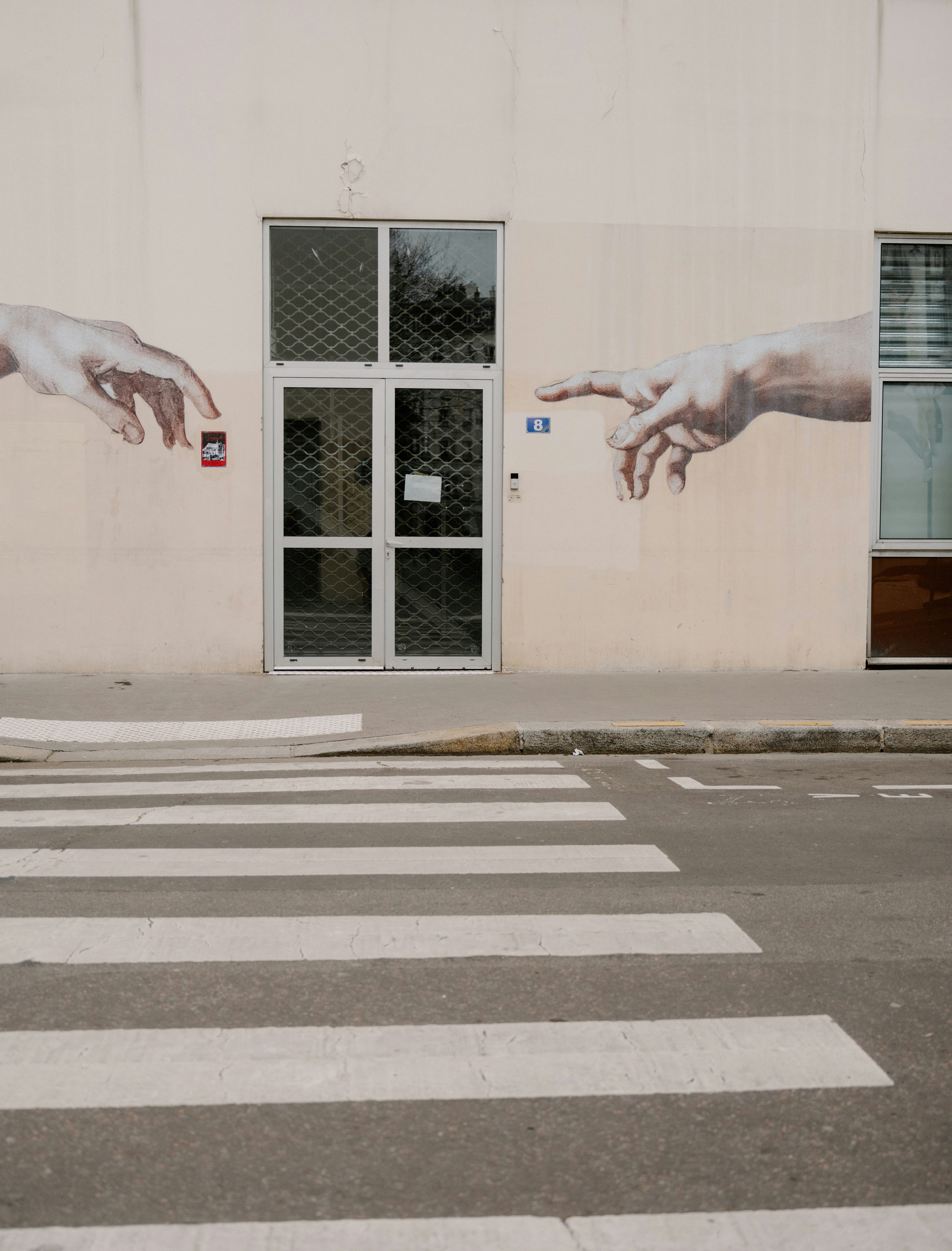 Hands on the Wall: Street mural framing a doorway