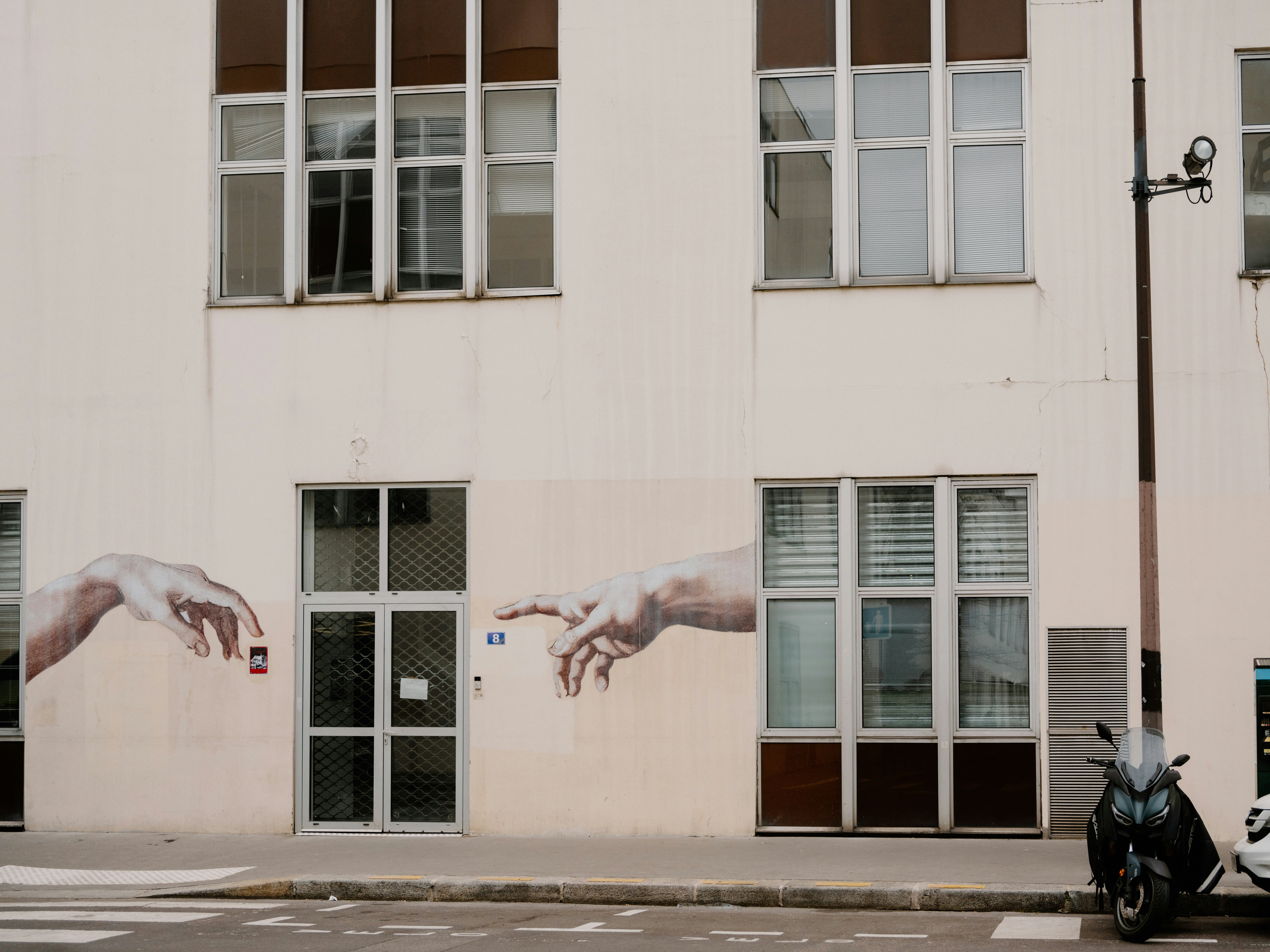 Hands Across a Facade: The Elusive Gesture Between Doors