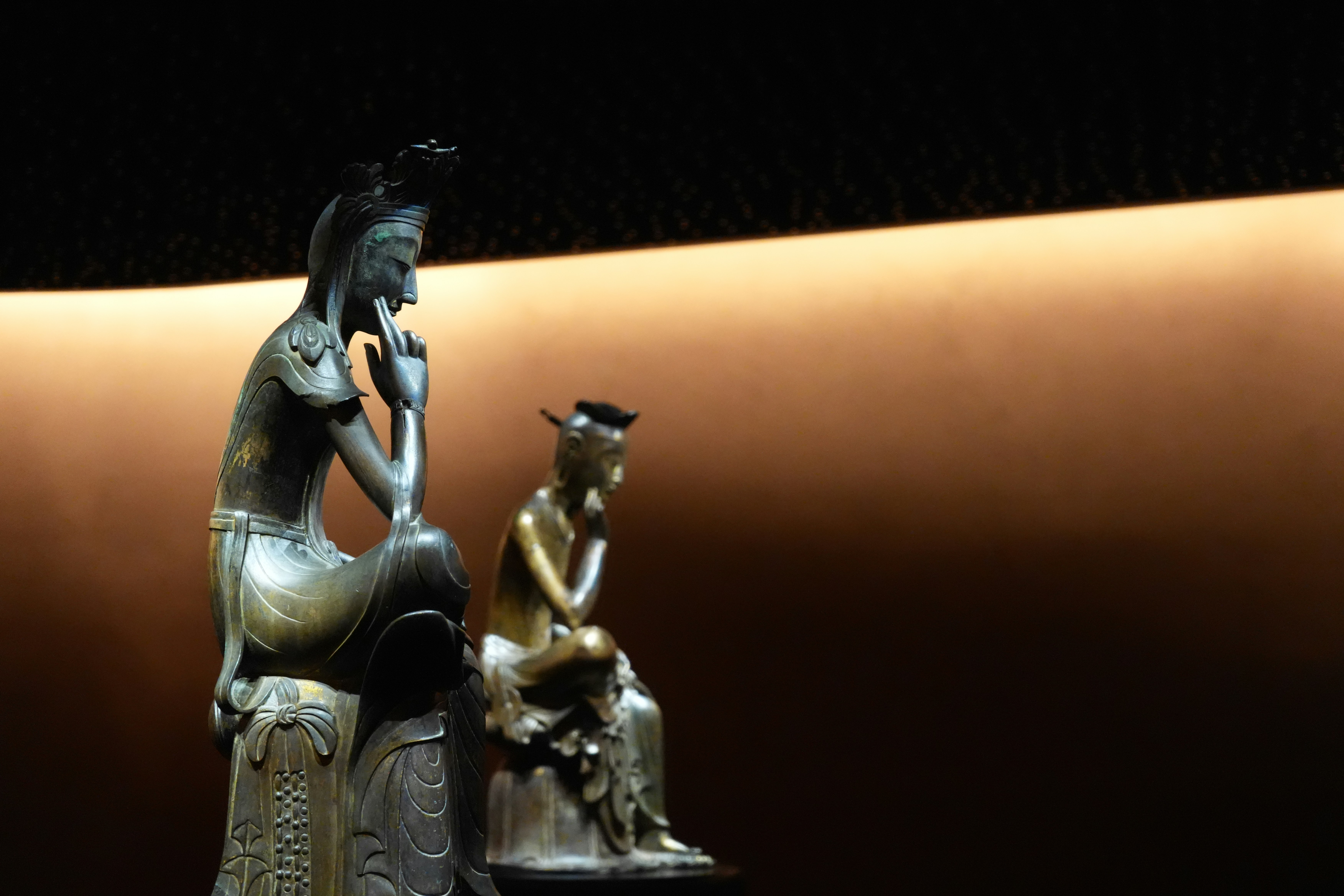 Silent Wisdom: A Pair of Phoenix-Study Figurines in Soft Spotlight