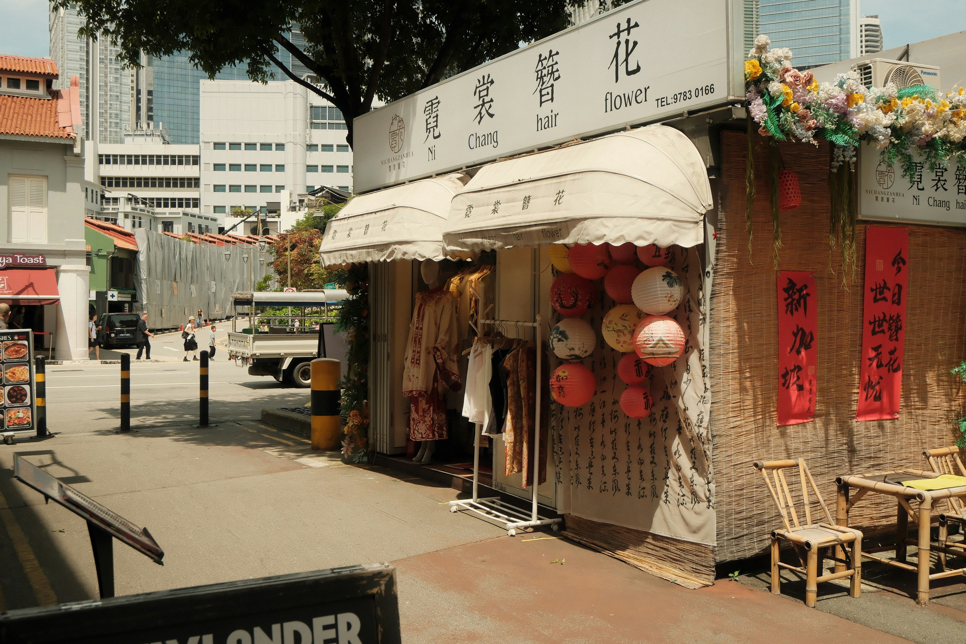 Market Stall with Lanterns and Signboard in a Sunlit Street