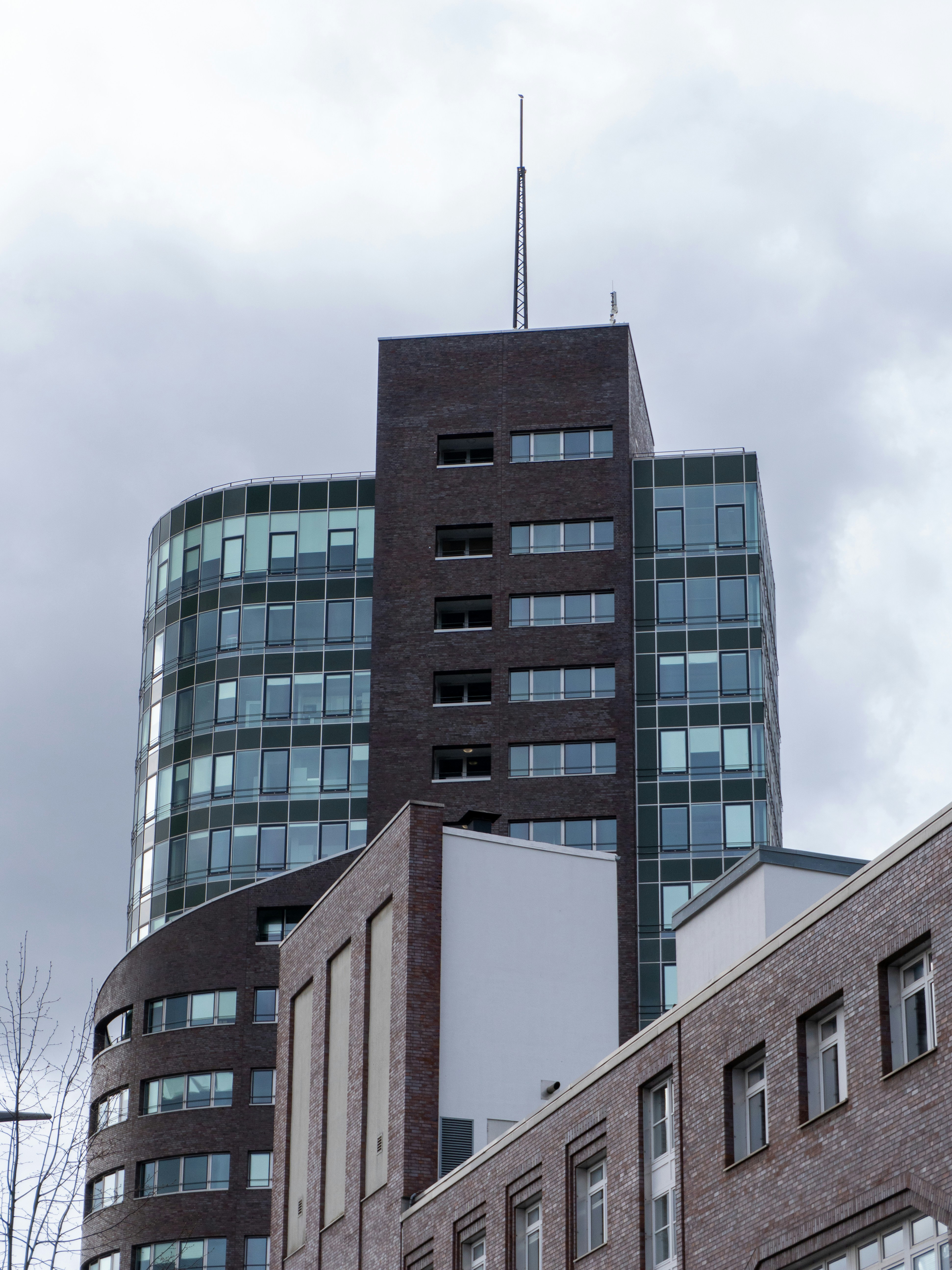 Skyward Facades: A Towering Assembly of Brick and Glass