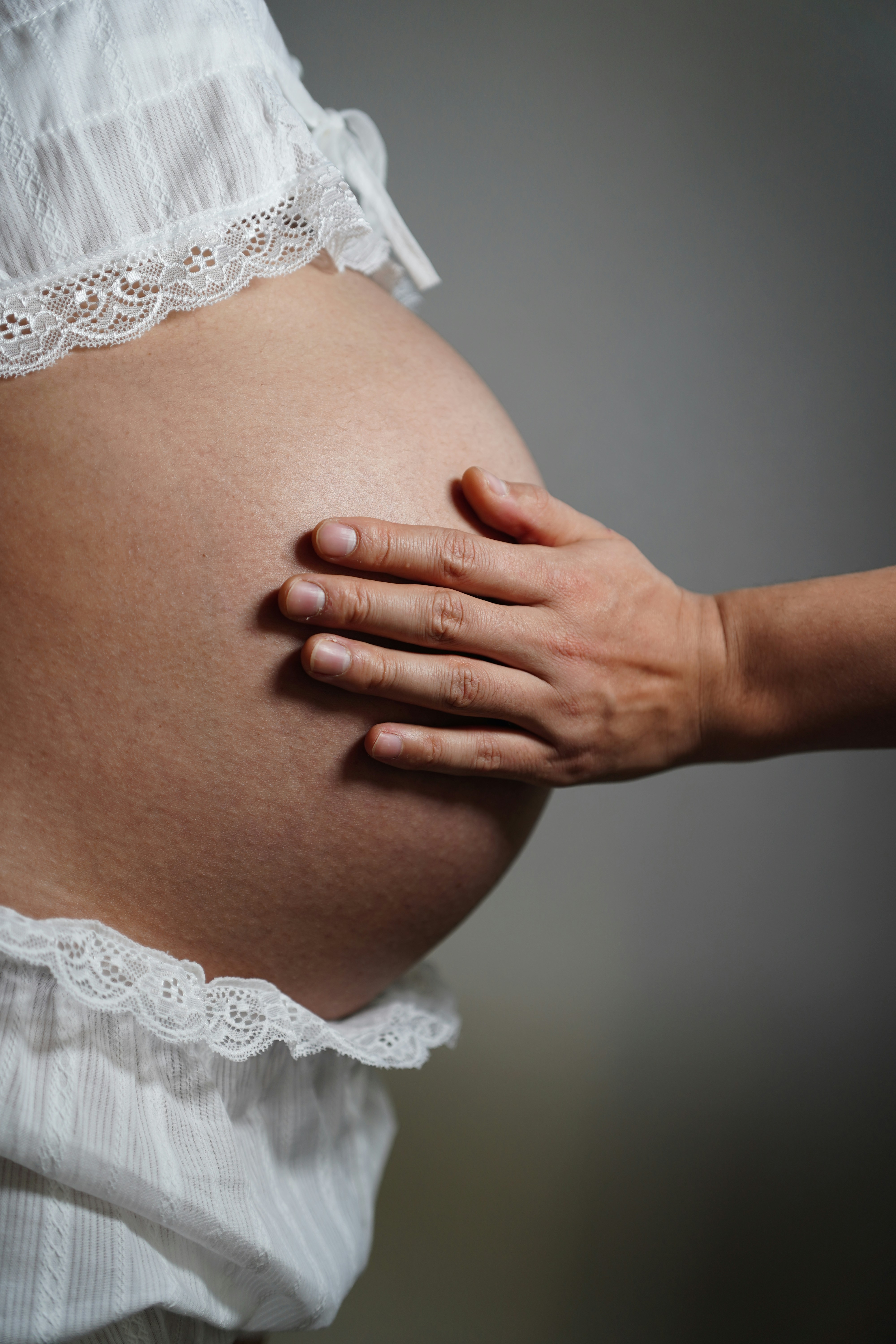 The Quiet Expectation: A Mother's Gently Braced Belly
