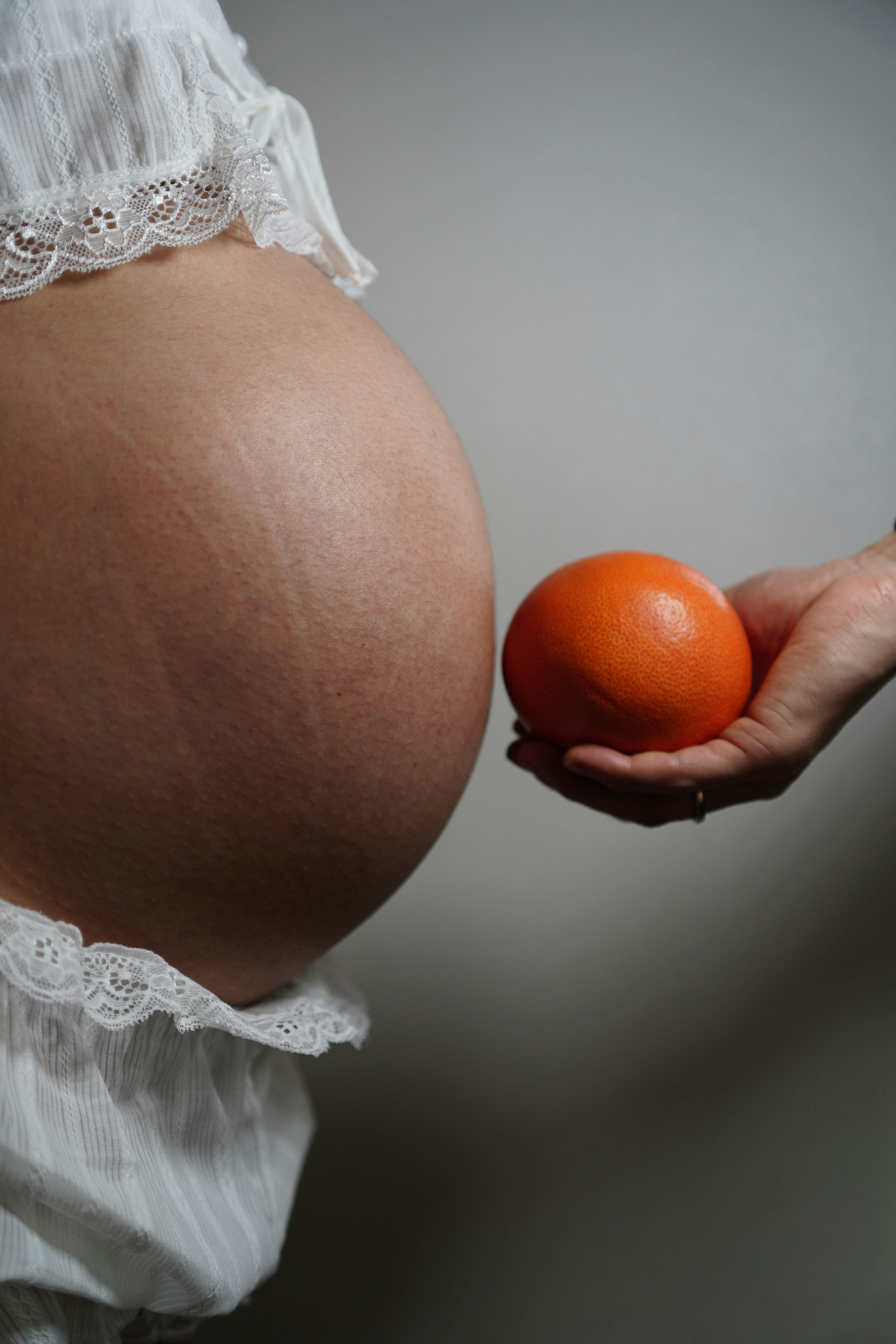 Glowing Expectation: a Pregnant Silhouette with an Oranges Moment