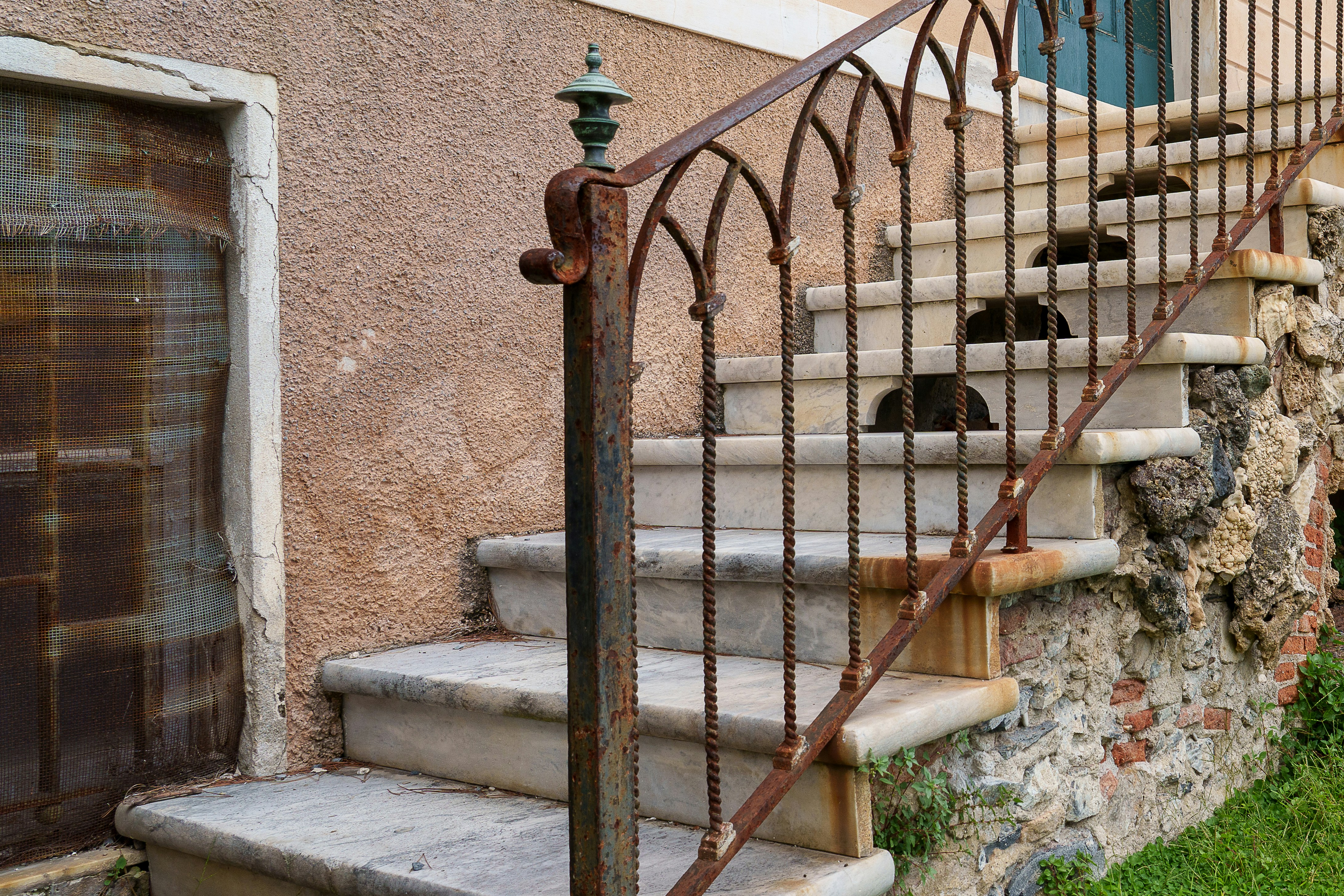Rust and Steps: A Weathered Staircase Clings to an Old Wall