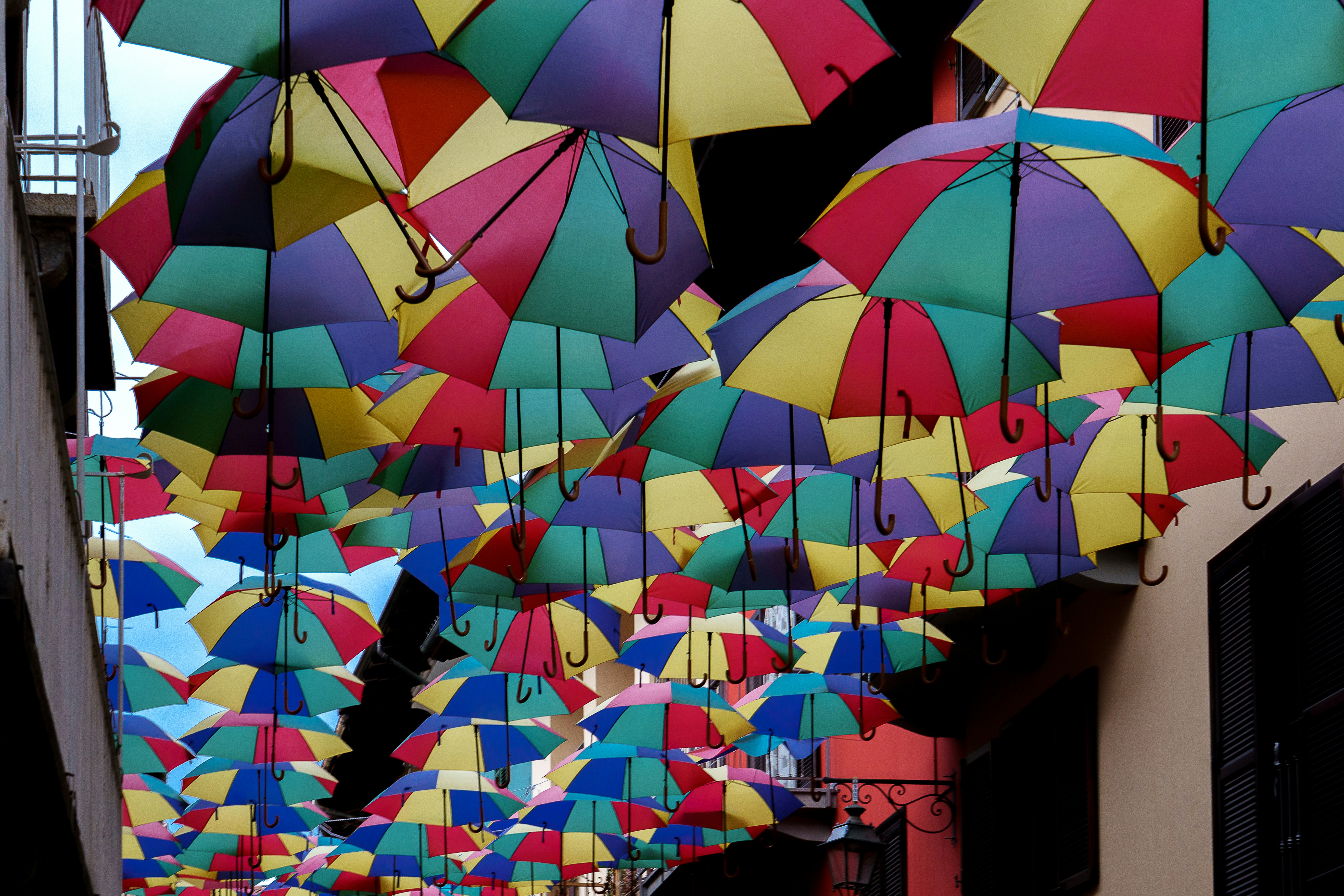 Colorful Umbrella Canopy over a Narrow Street