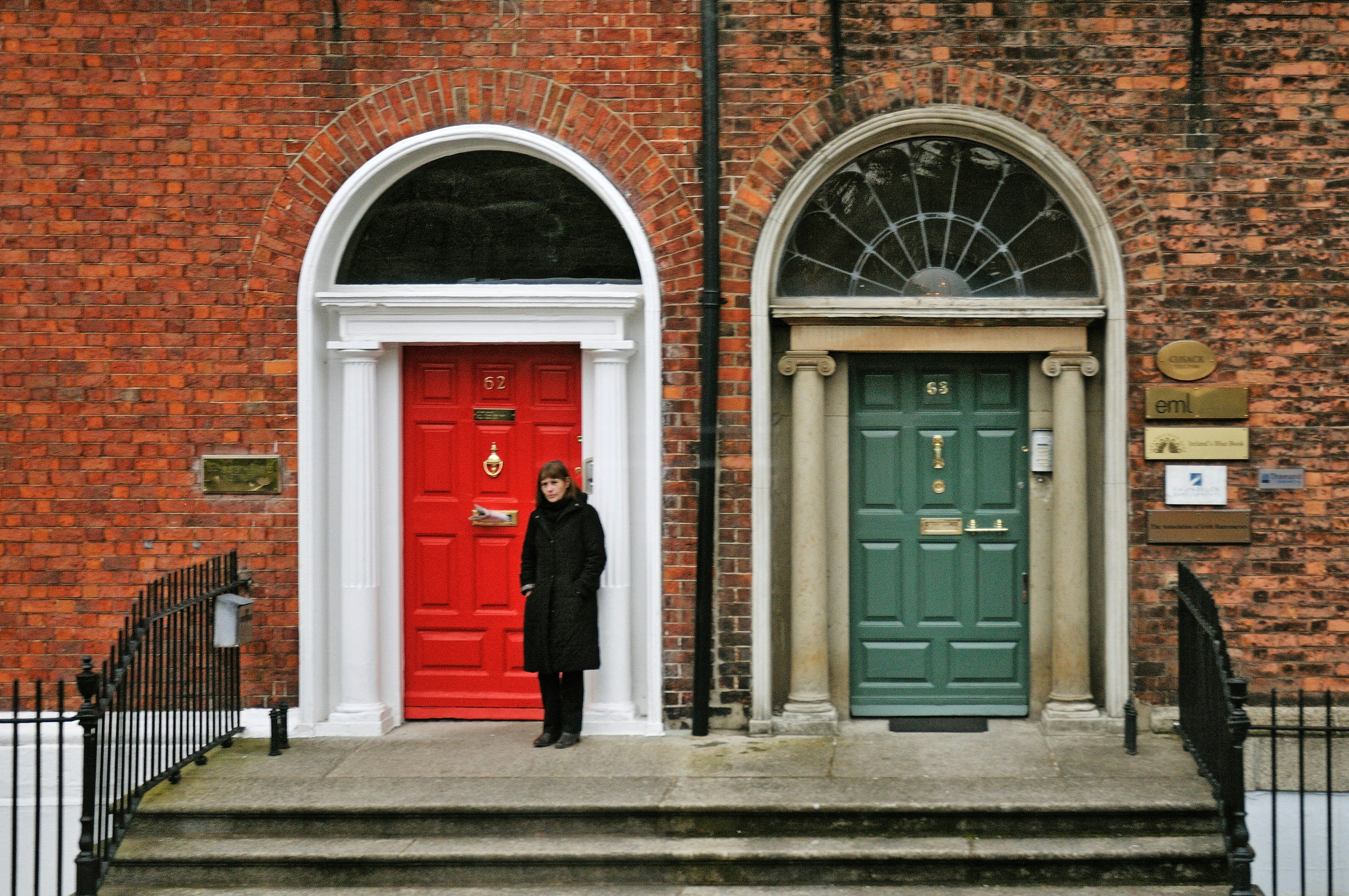 Red Door, Quiet Figure: A Moment Between Arches