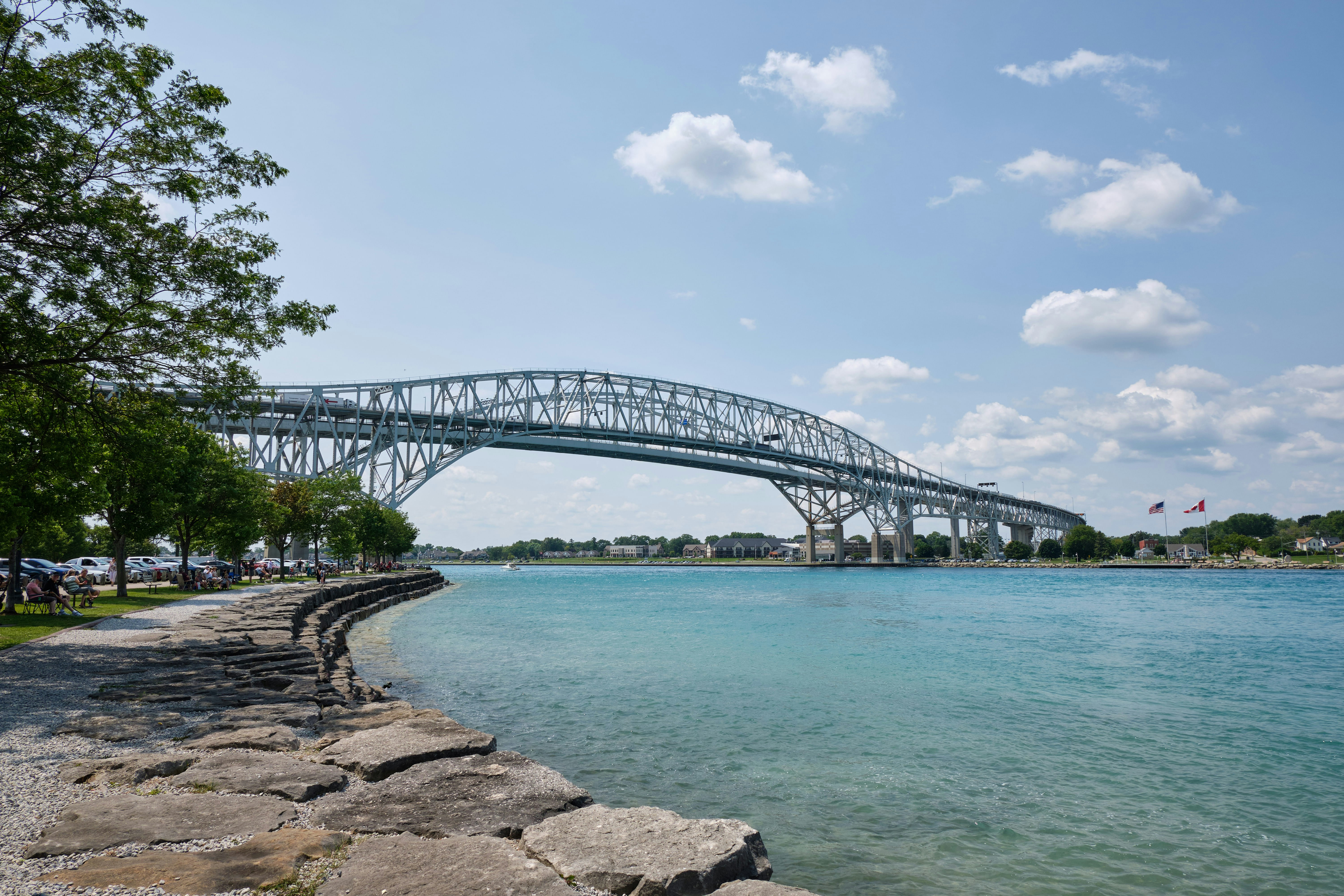 Arched Bridge Over Calm Blue Water by a Stone Promenade