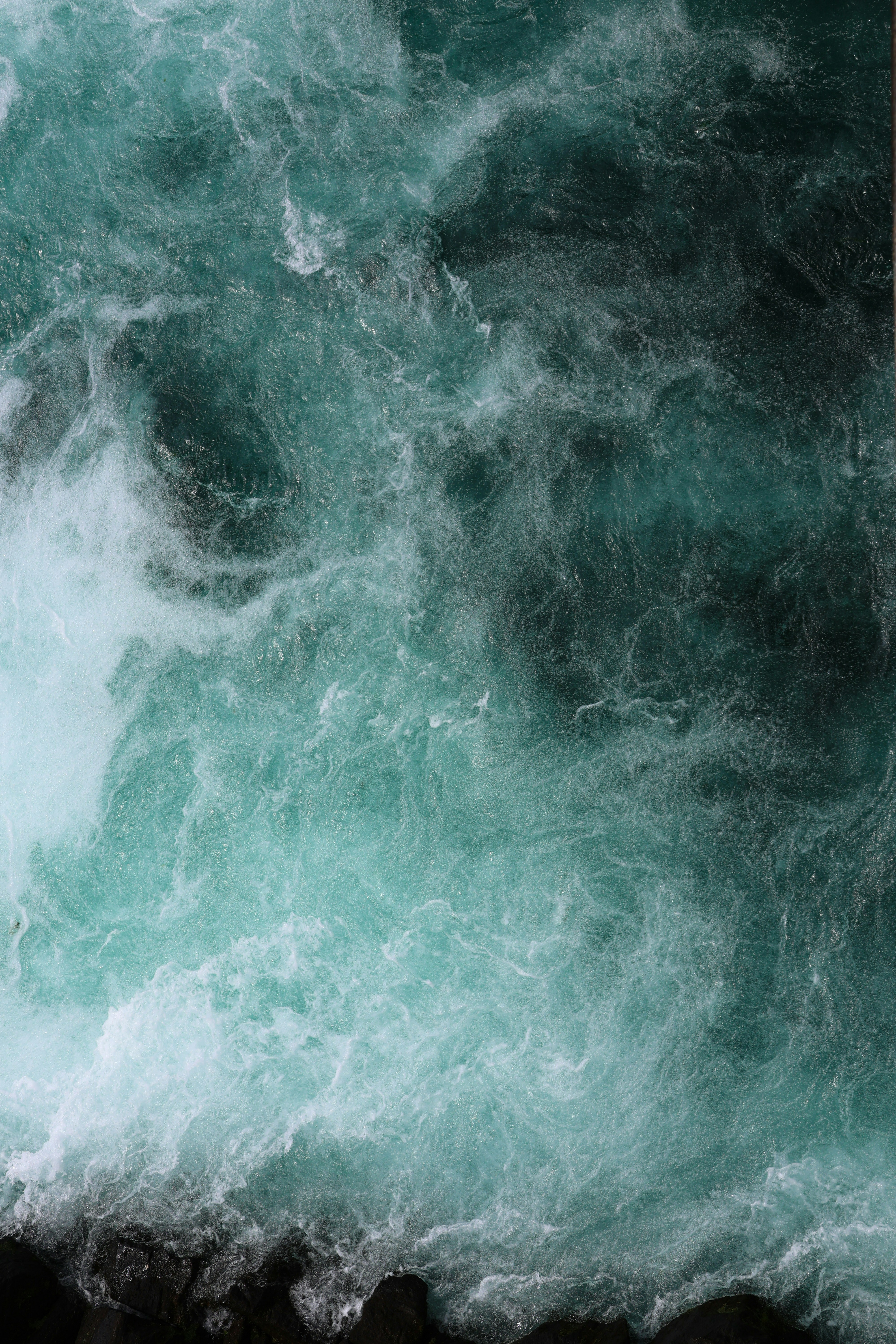Turquoise Surge: Aerial Aegean Ripples Crashing Along the Shore