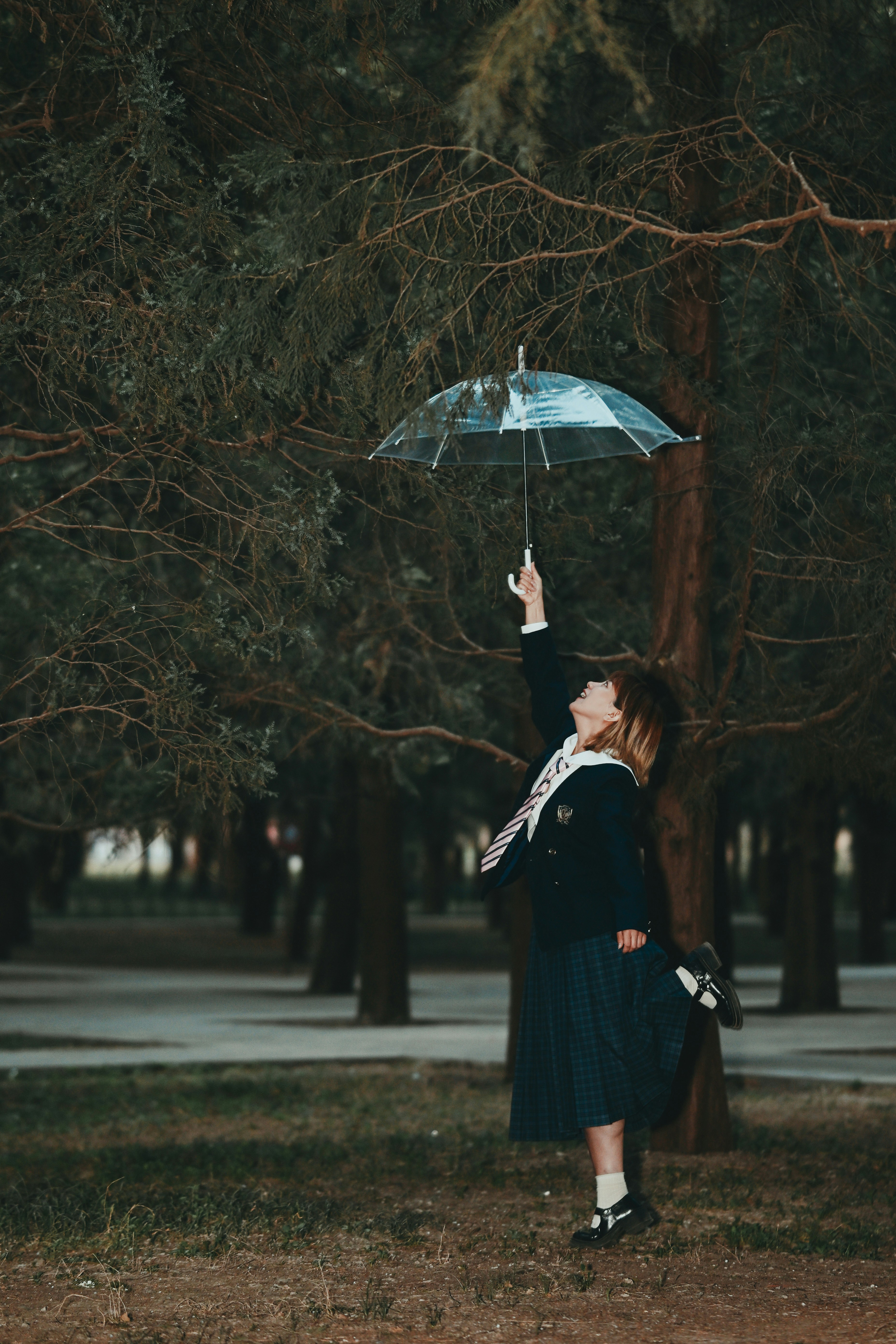 Umbrella Lift: A Student Reaches for Rain with Poise