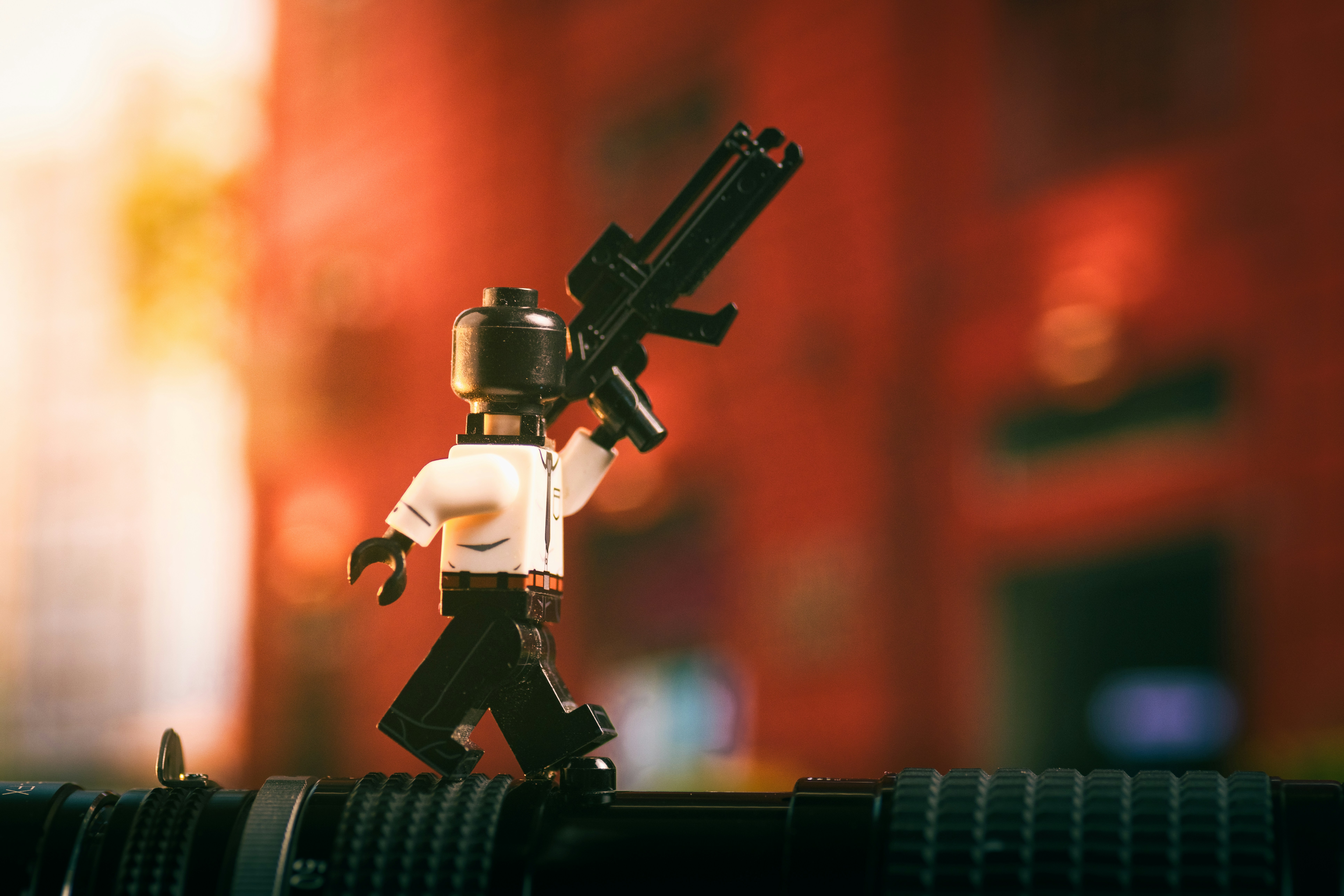 Lego Hero with a Miniature Railgun Stands on a Lens