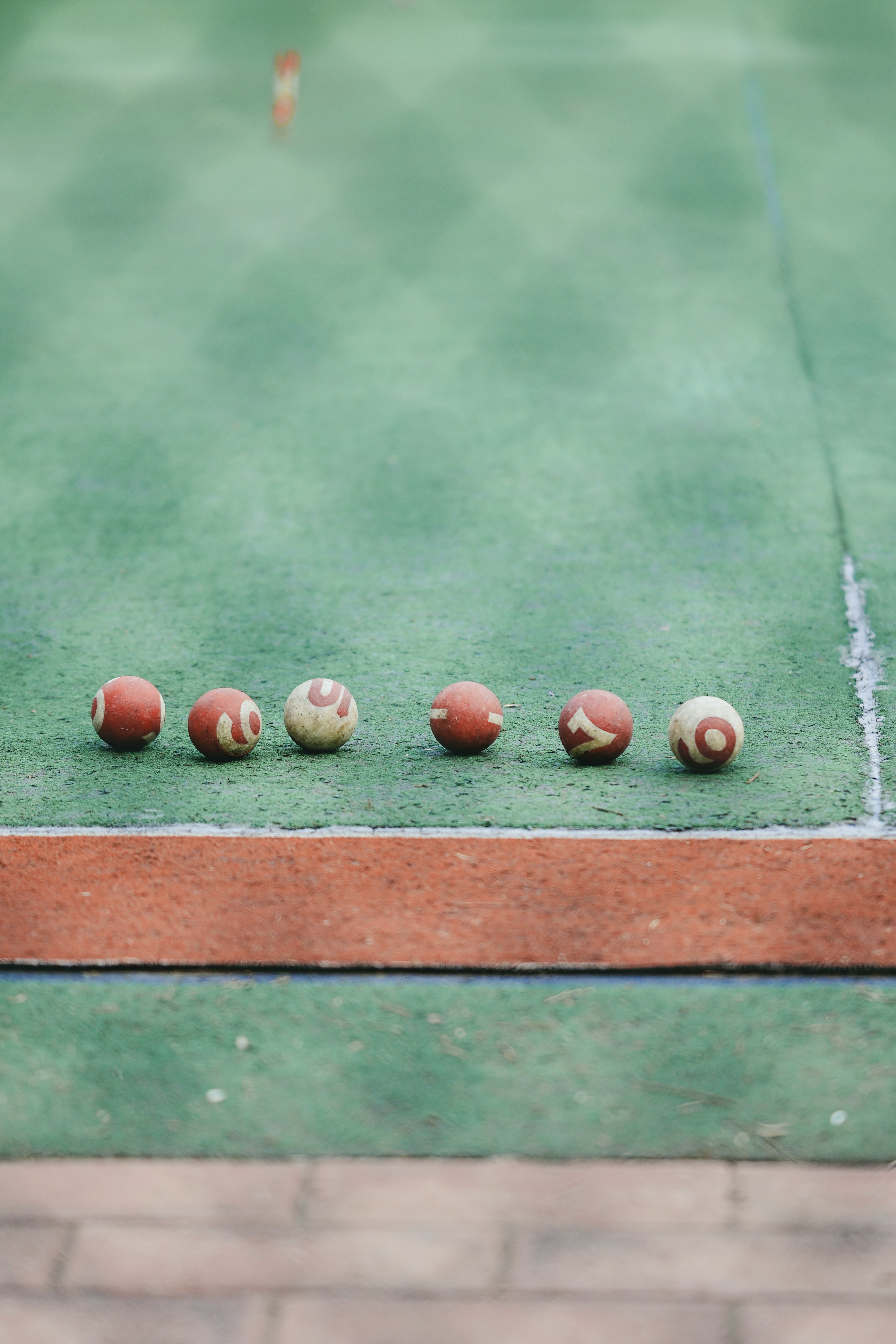 Row of vintage balls on a tennis-style court edge