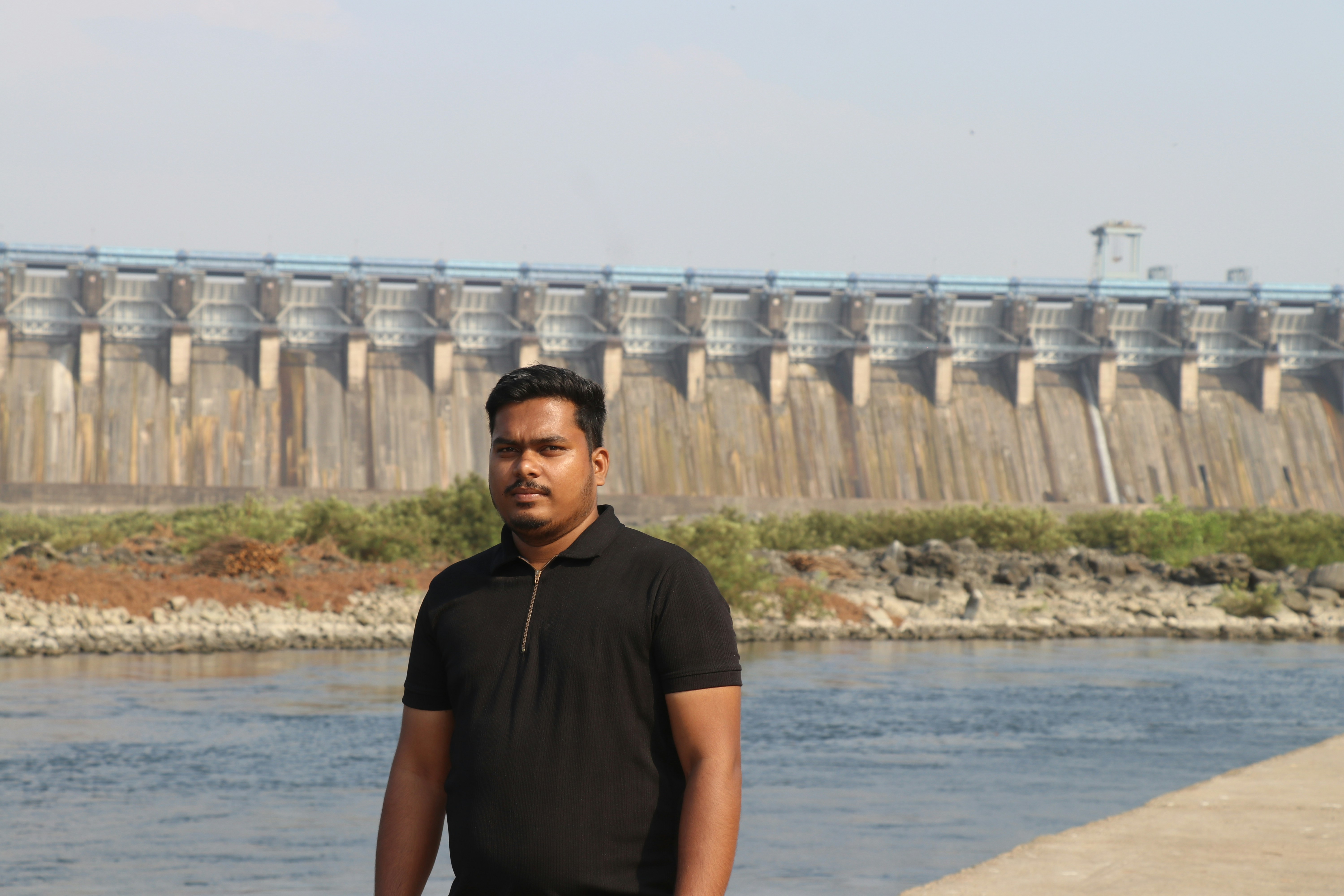 Portrait by the Dam: A Quiet Moment with the River and Structure