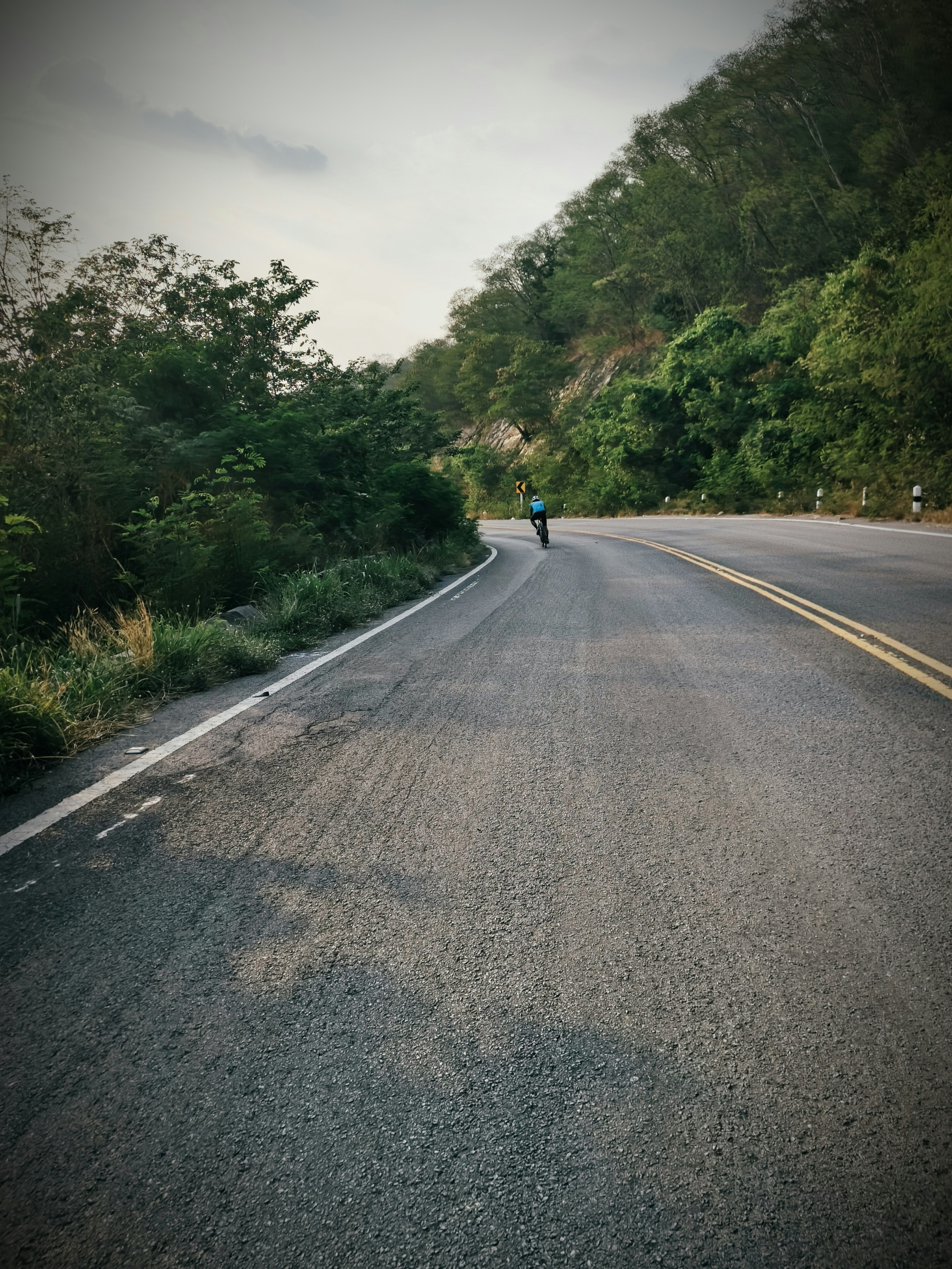 A lone rider on a winding mountain road