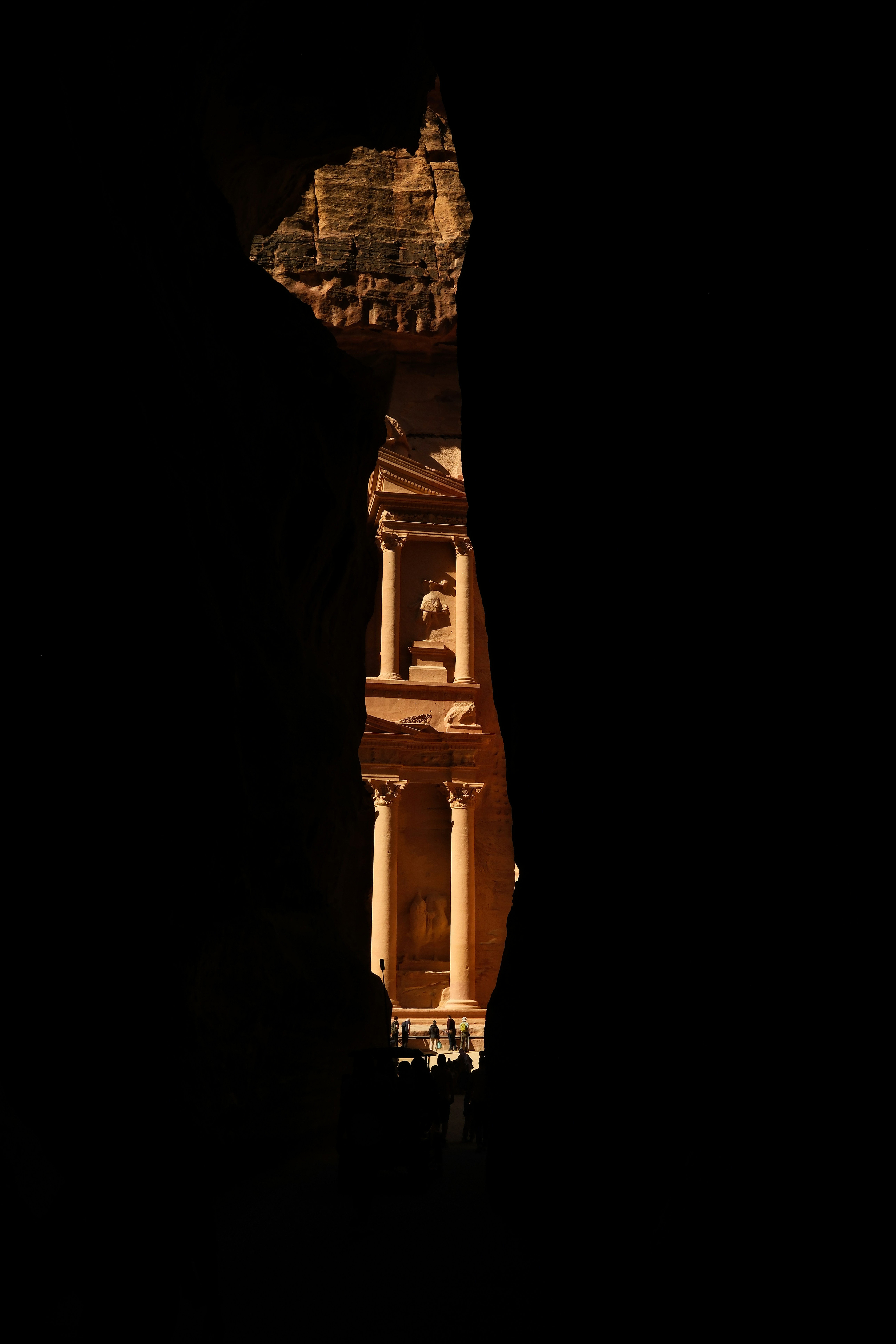 Temple Torch in the Narrows: Carved Monolith Emerges from Darkness