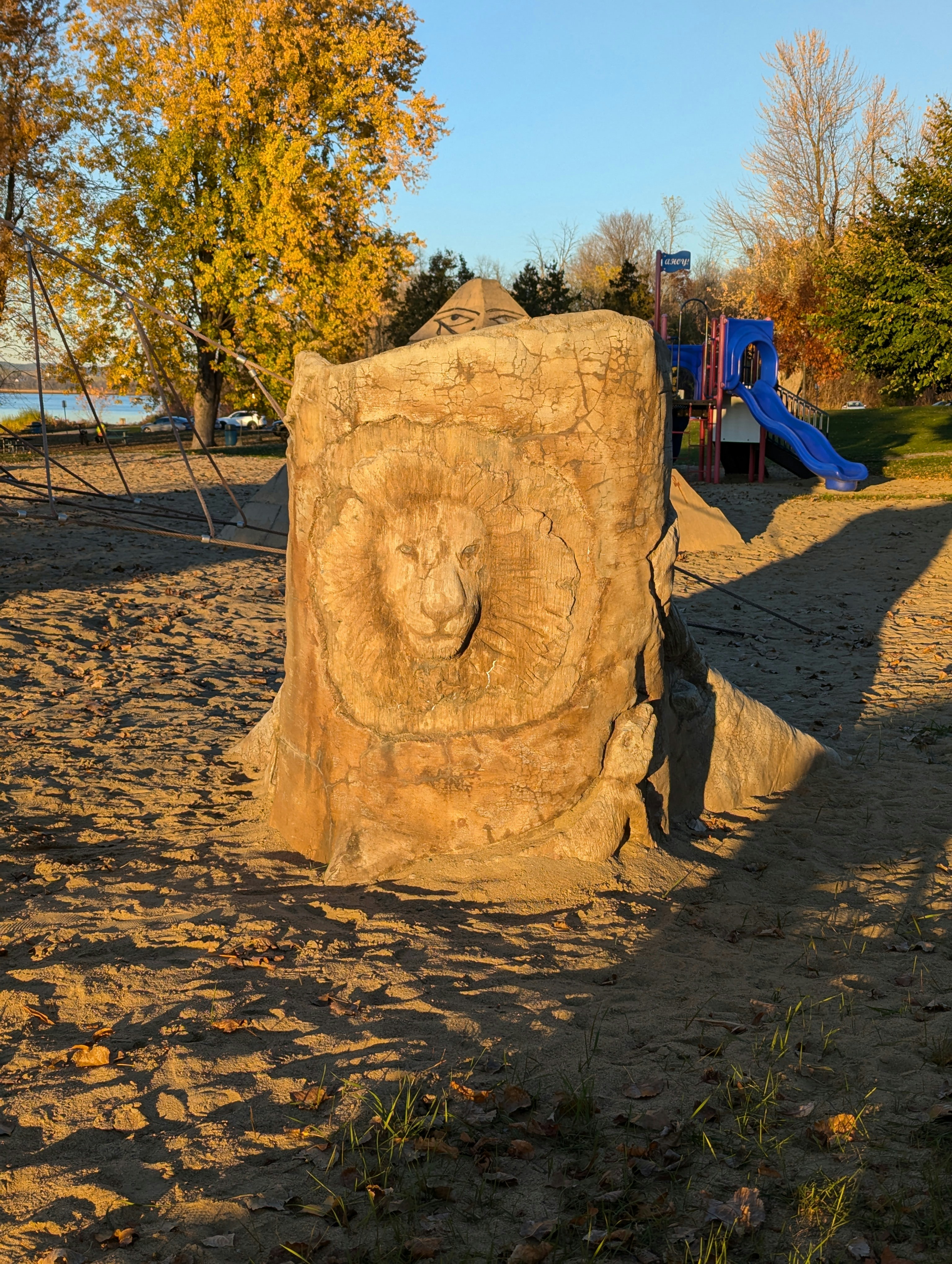 Sunlit Sandstone Lion Guards a Quiet Playground