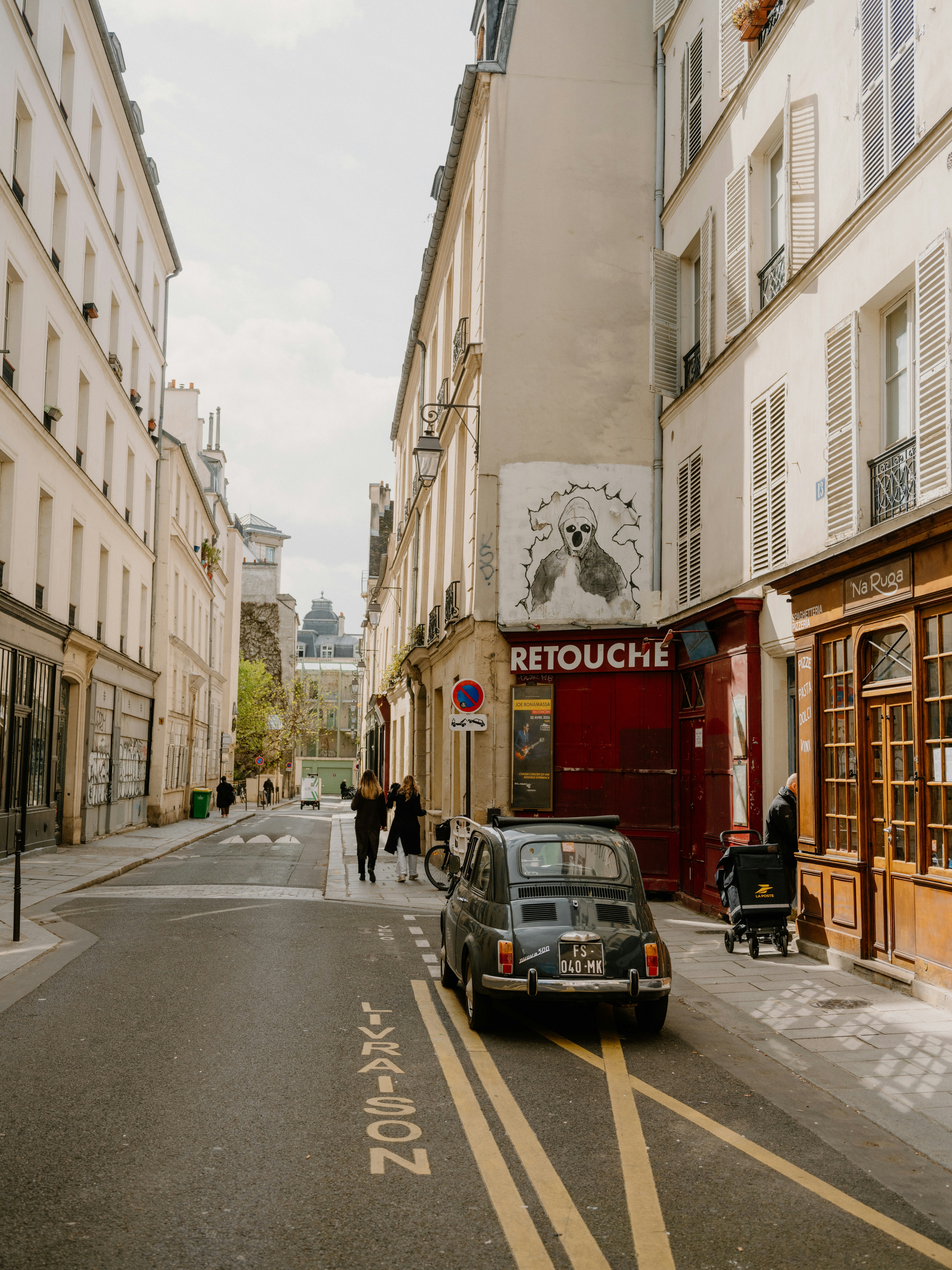 Cobbled Paris Alley with a Stubborn Taxi and a Ghostly Wall Mural