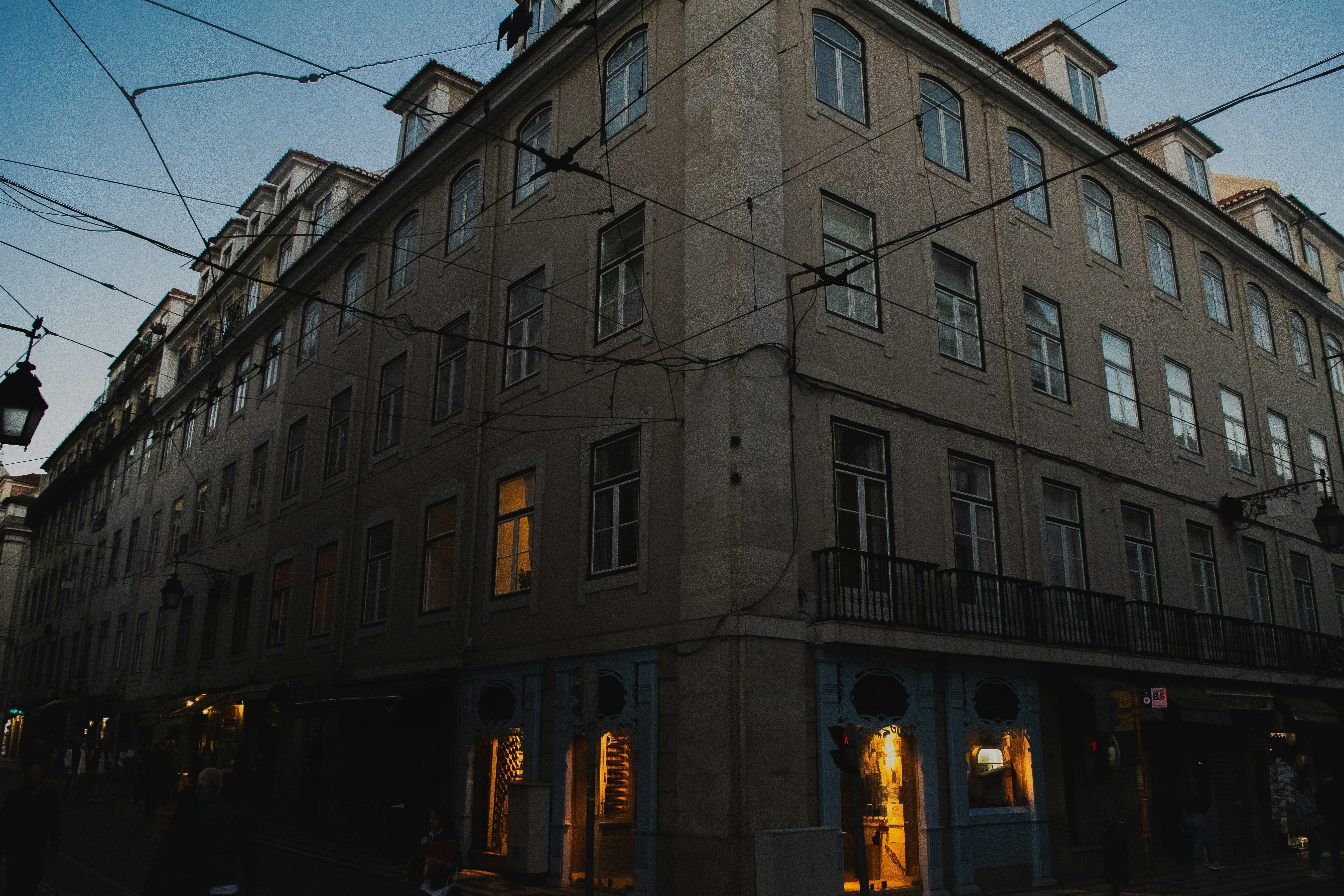 Corner building with illuminated windows at dusk