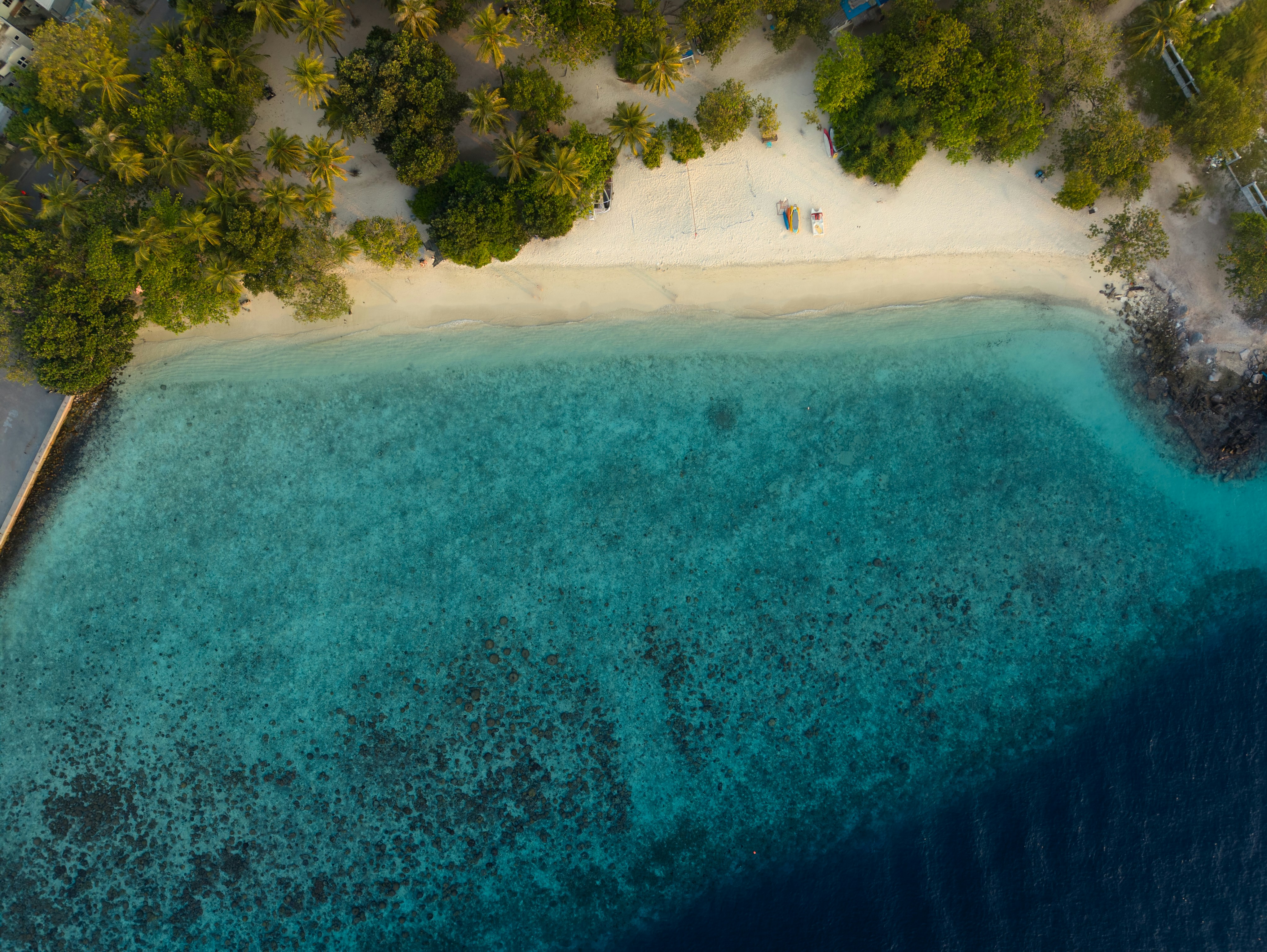 Aerial calm: turquoise reef meeting a sandy shoreline