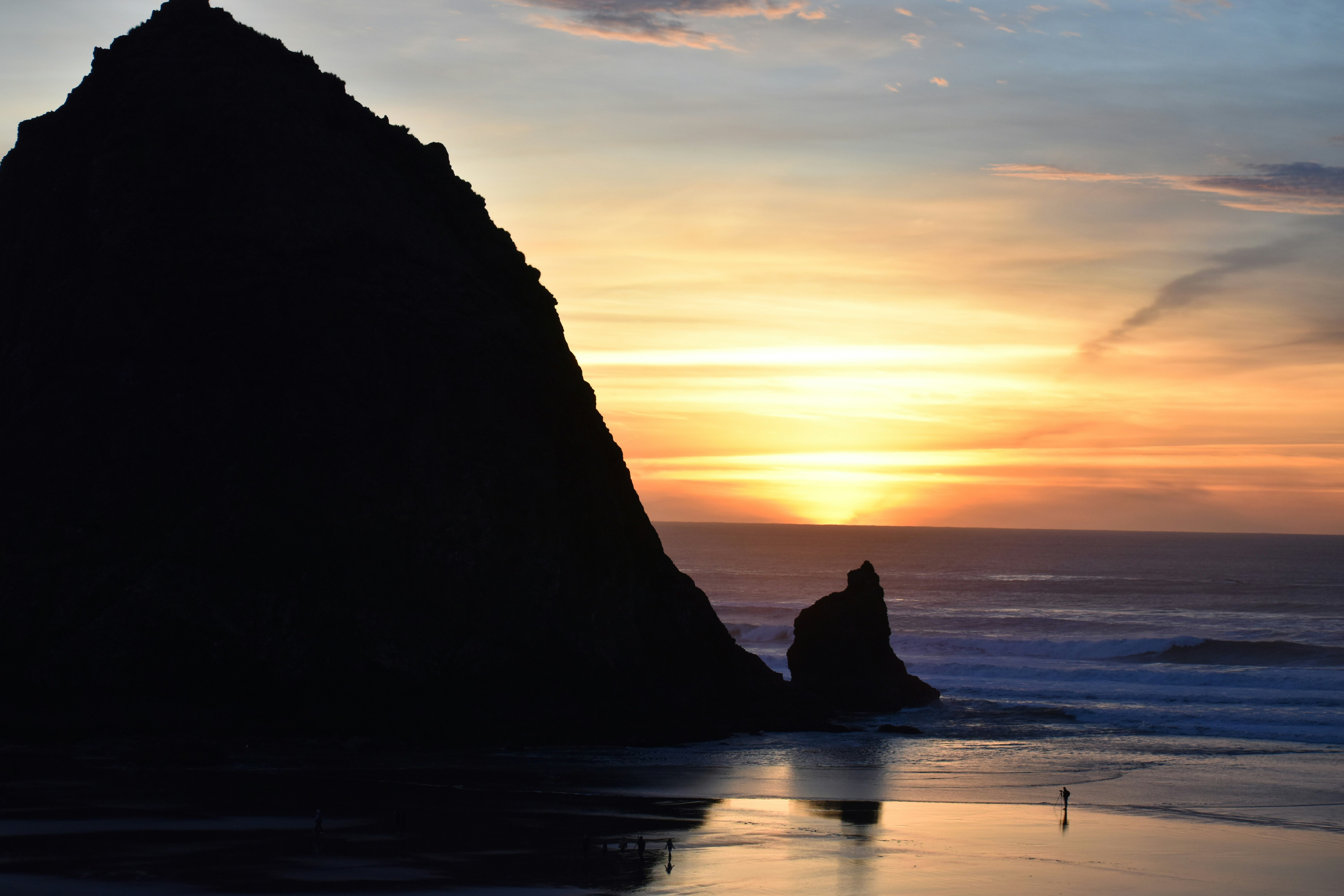 Silhouette at Sunset: A Giant Cliff Embraces the Quiet Shore