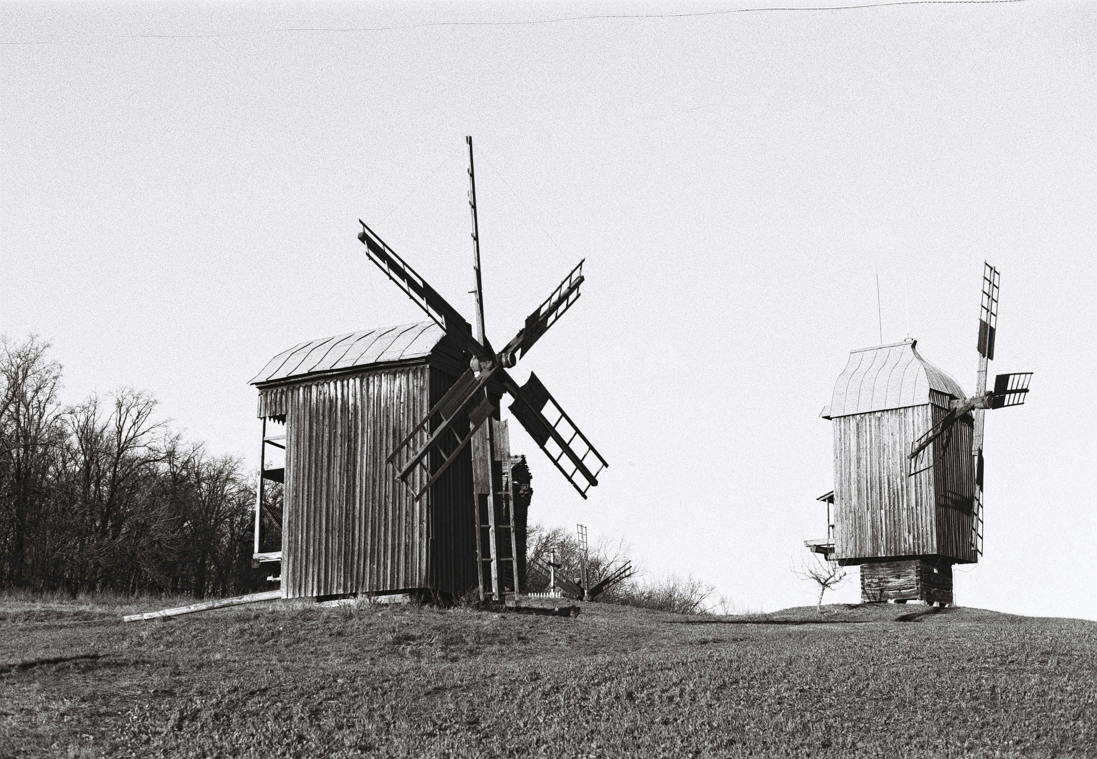 Two Weathered Windmills on a Gentle Hill