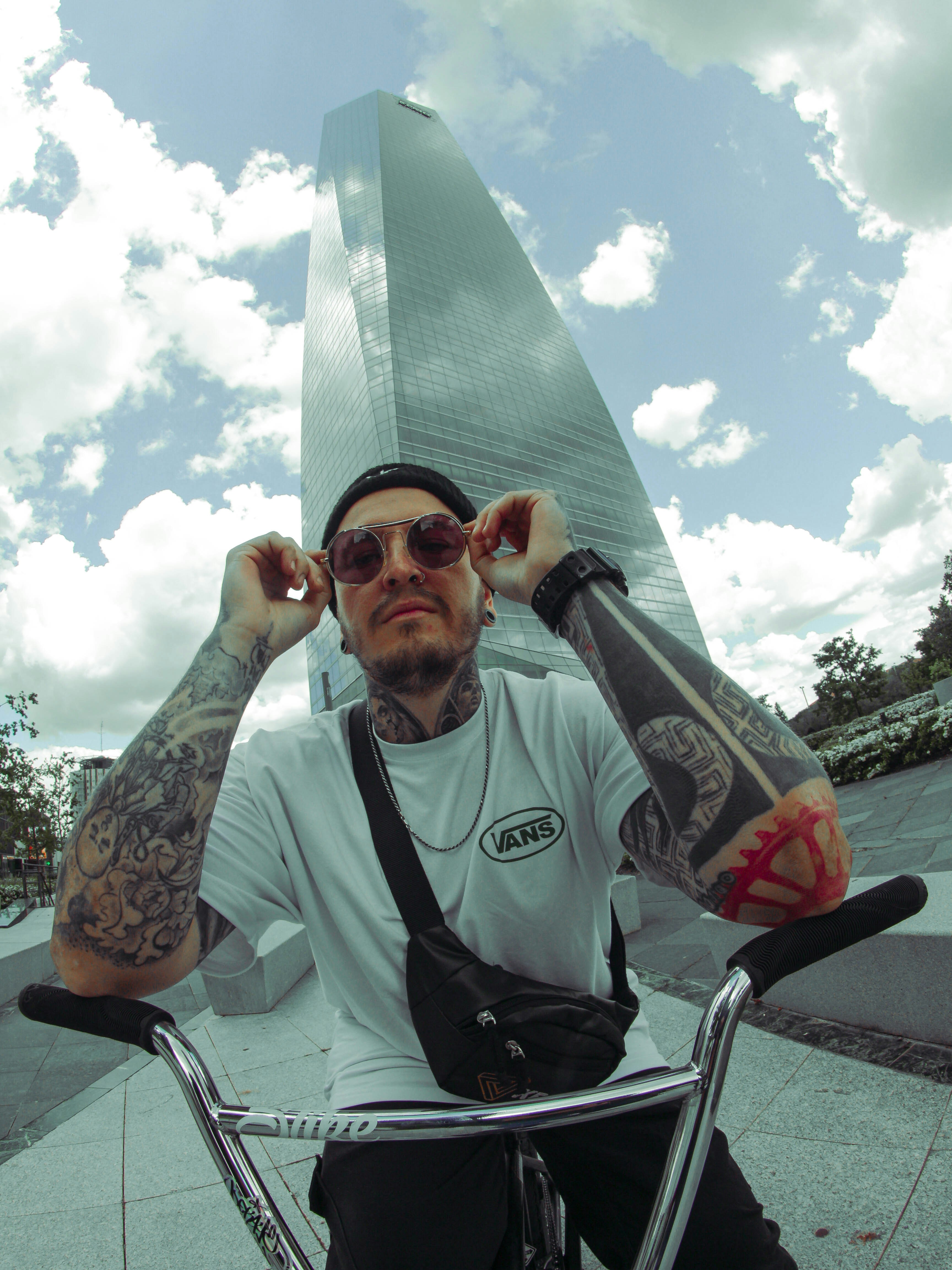 Rider’s Gaze: Tattooed Portrait Beneath a Towering Glass Obelisk
