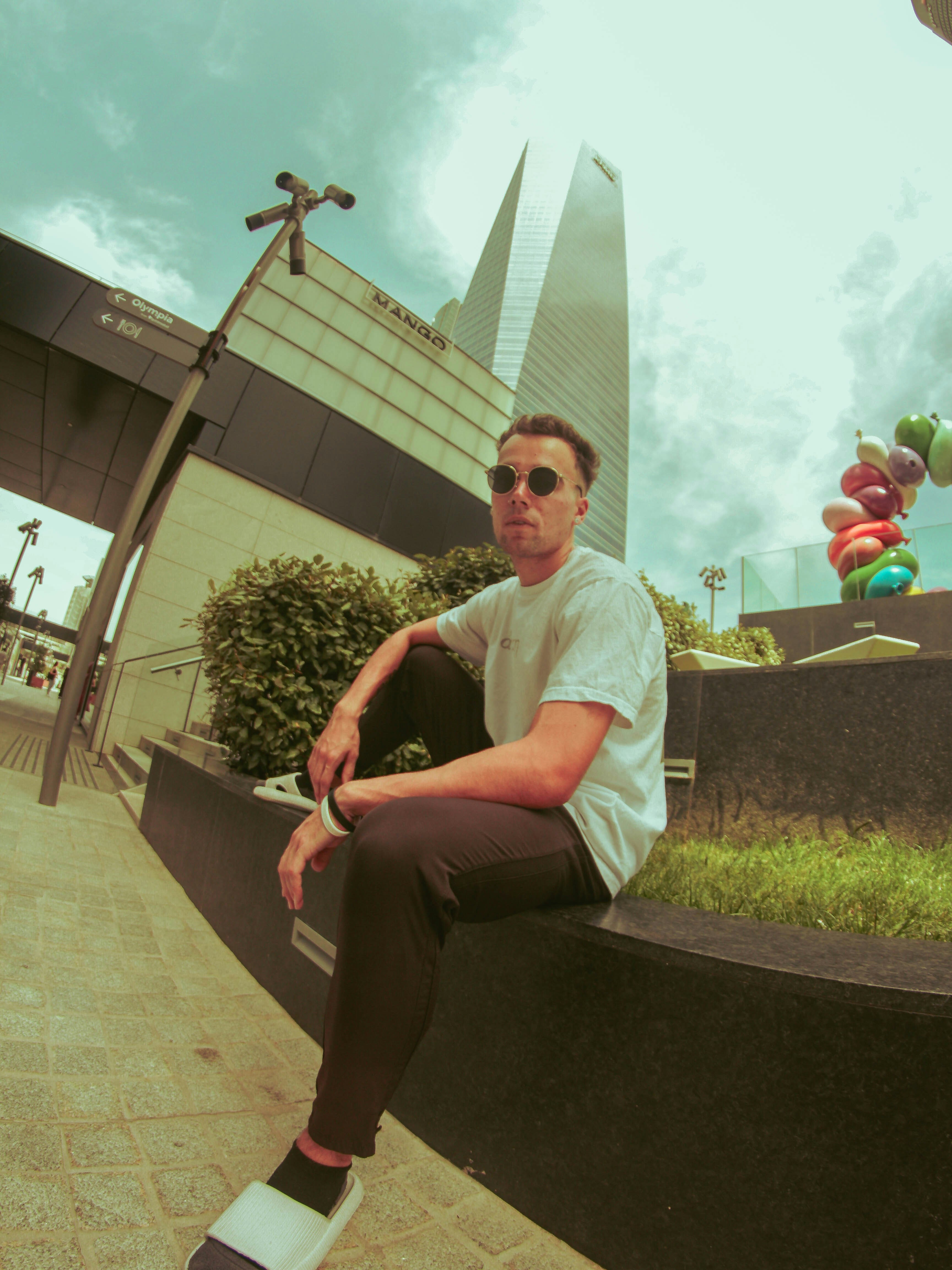 Urban Portrait Under Skyscrapers: A Quiet Moment Amid Colorful Balloons