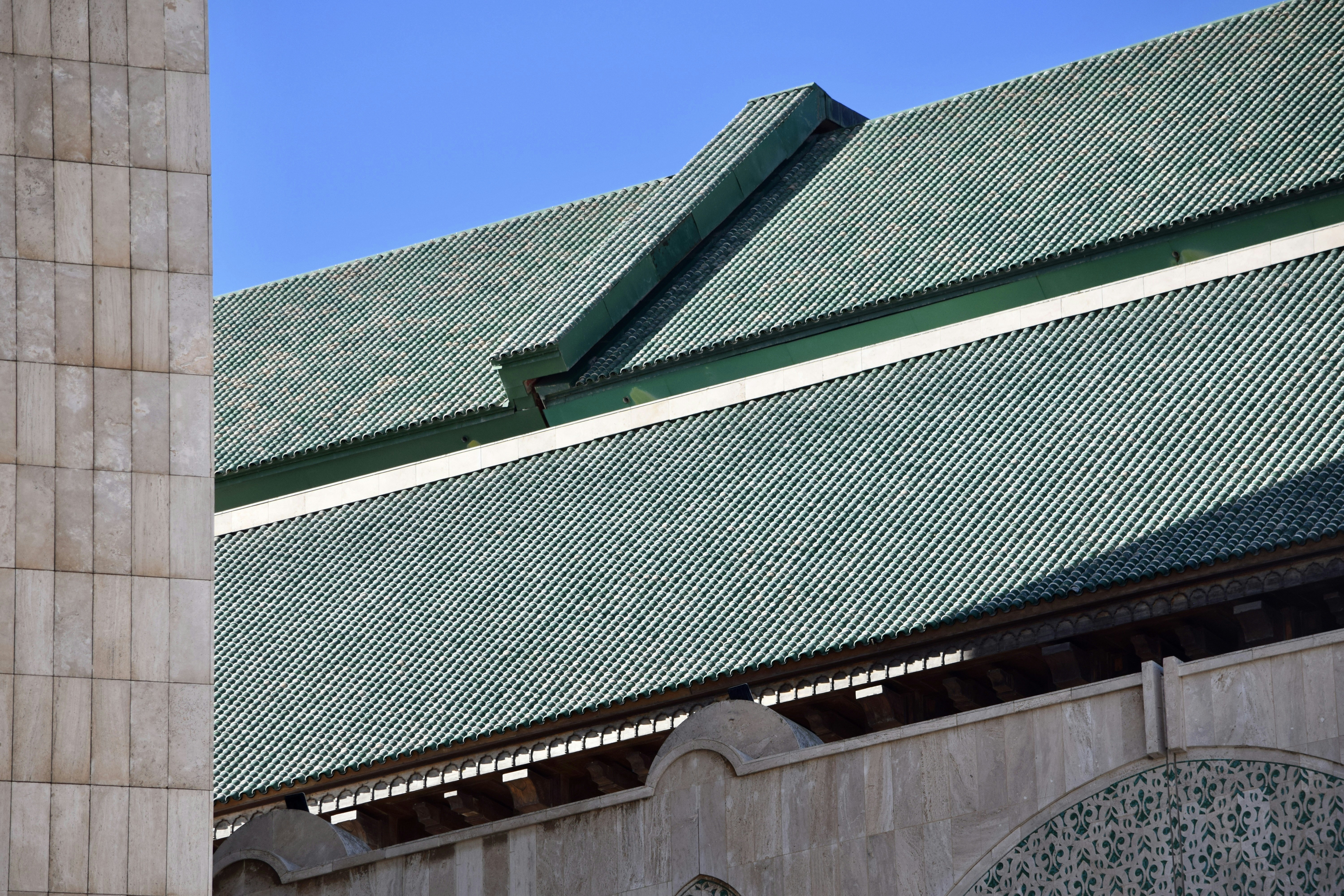 Green tiled roof lines under a crisp blue sky