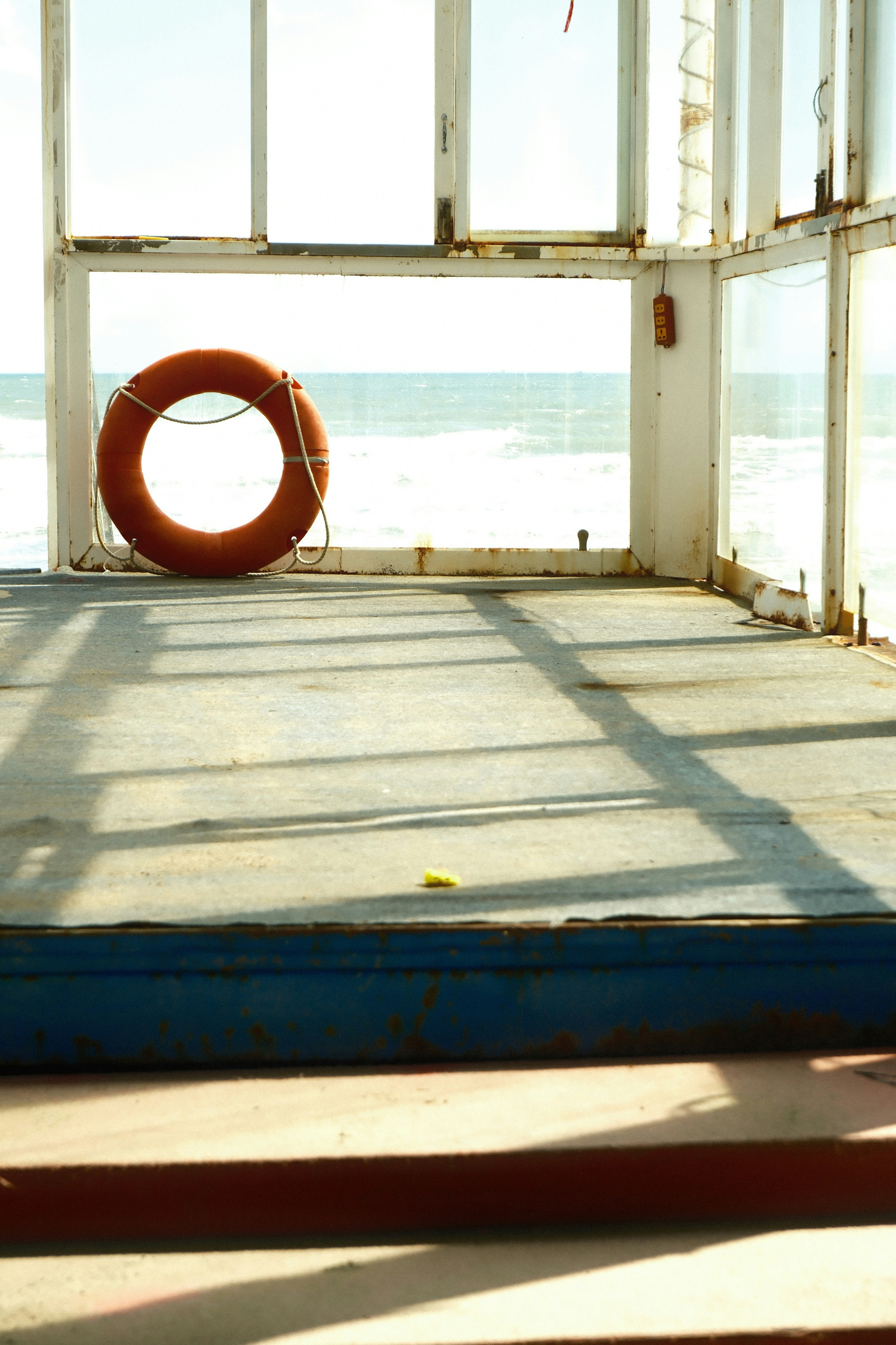 Lifebuoy and Light: Sunlit Pier Steps Framing the Open Sea