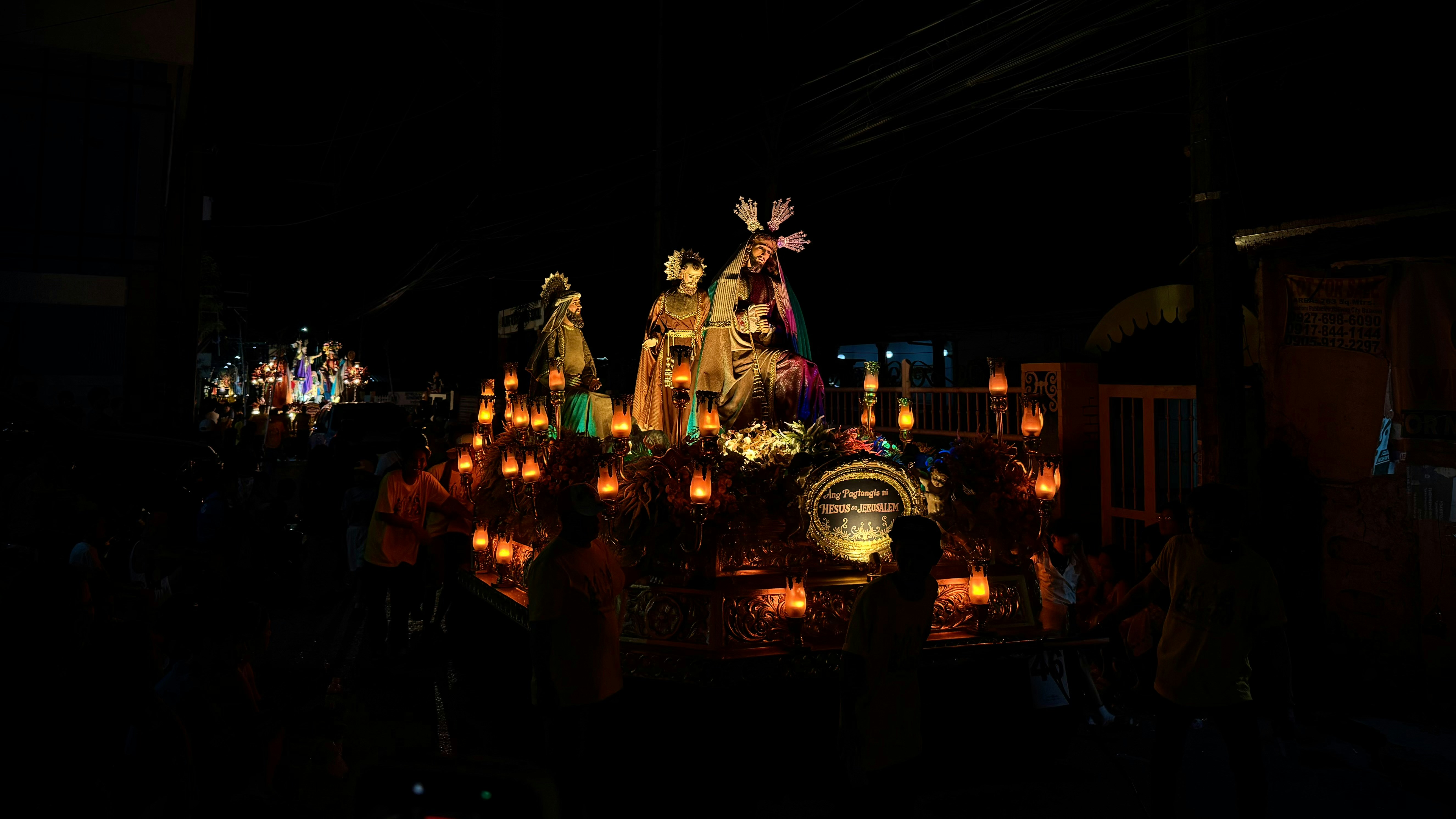Glow-carved Procession: Night Shrine Emerges from Shadowed Crowd