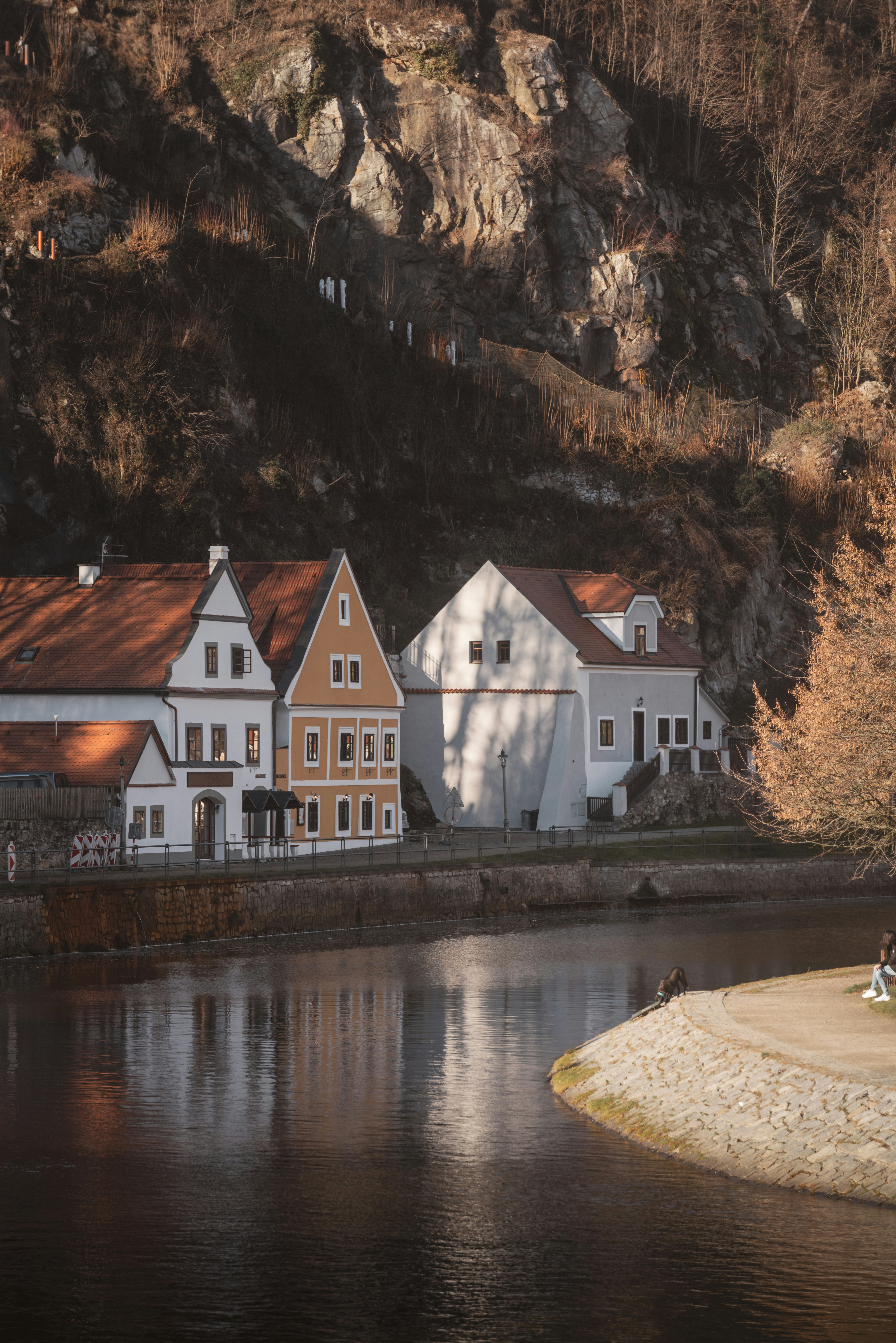 Quaint Row of Riverside Homes Nestled at the Base of a Cliff