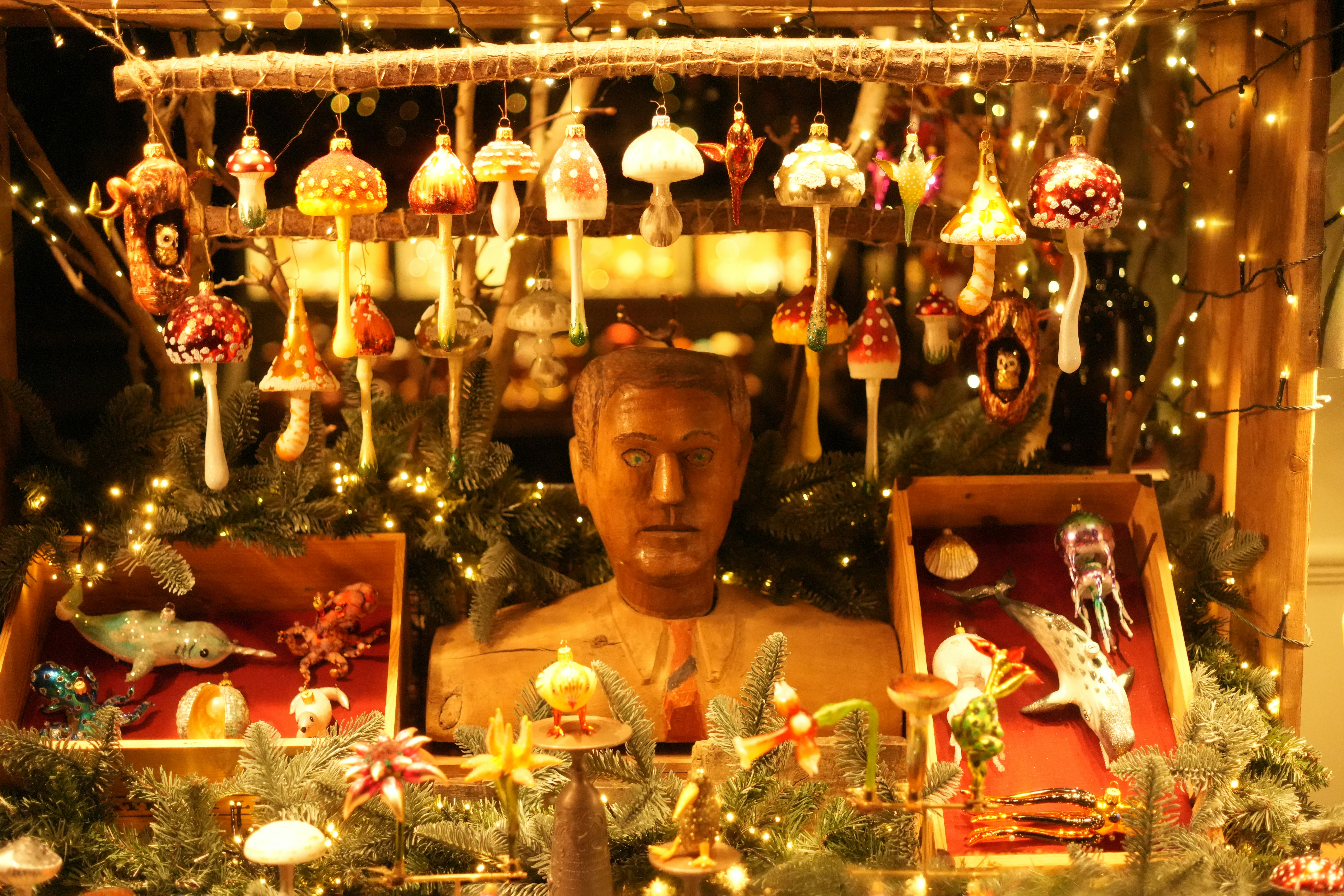Muse of Lanterns: A Wooden Head Among Glowing Treasures