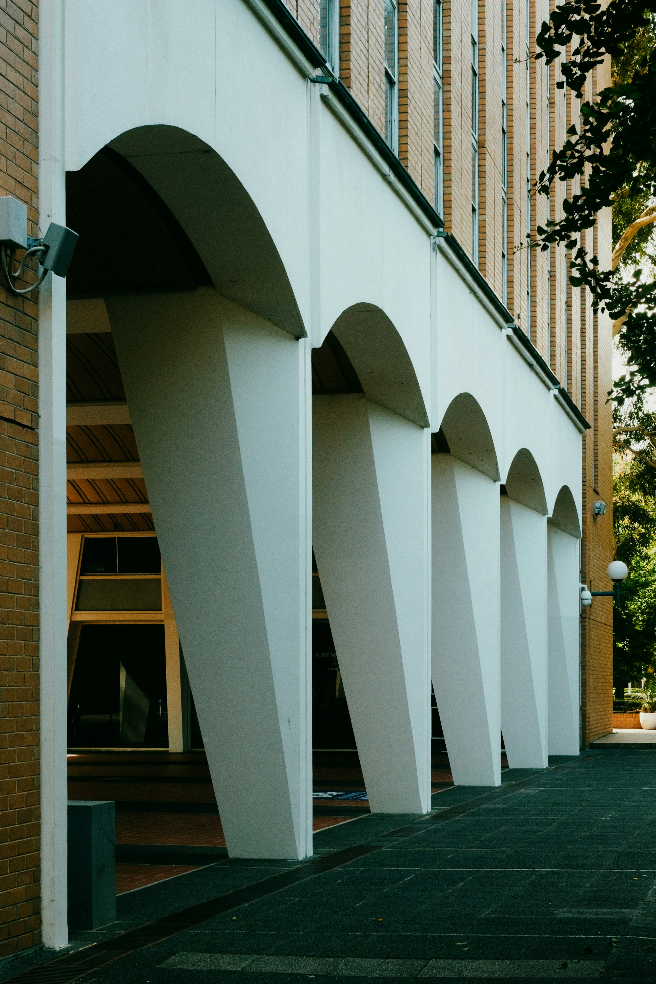 Archway Rhythm: Repetition of Concrete Curves along a Brick Facade