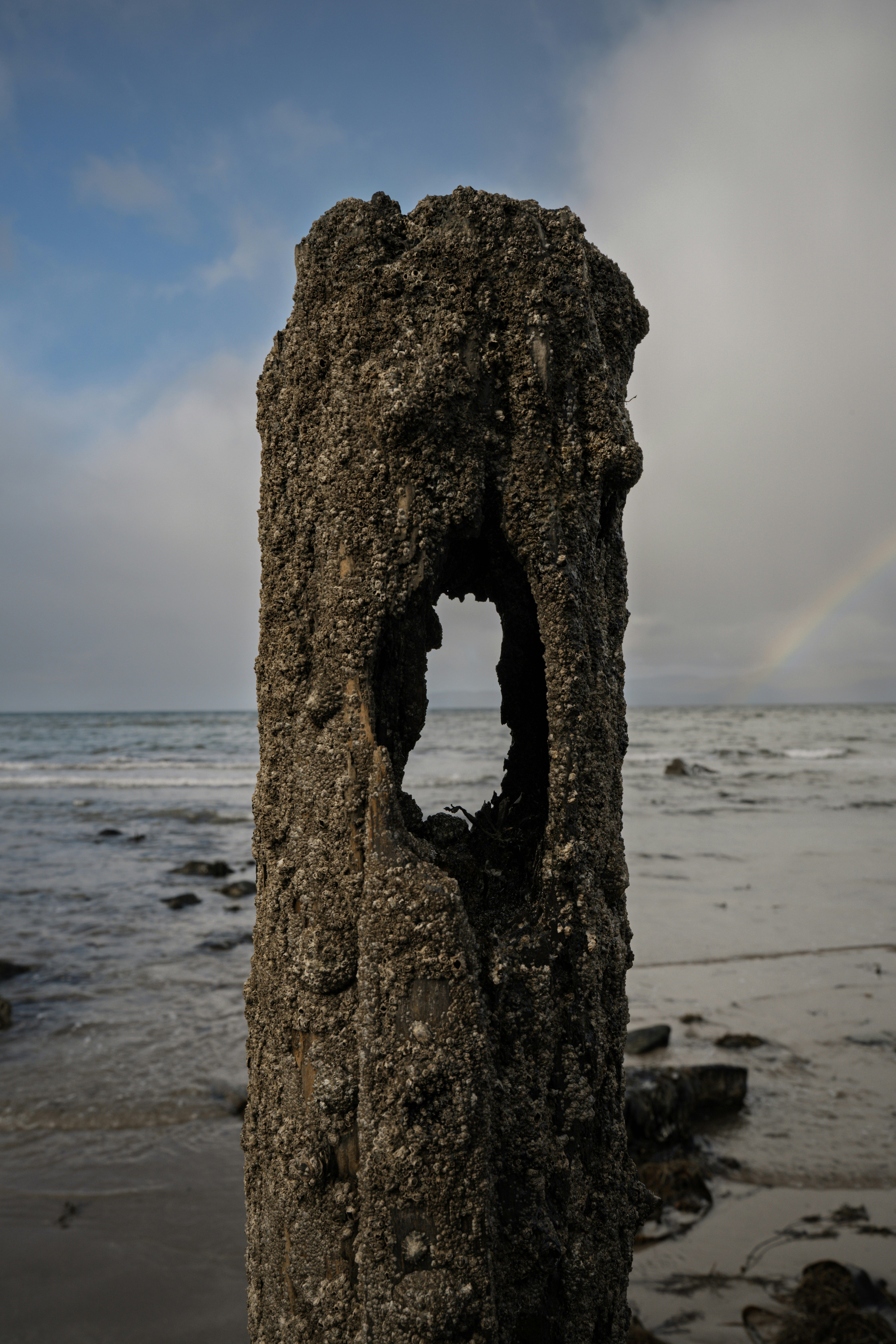 Stone Gate at the Shore: A Weathered Monument Framed by Sea and Sky